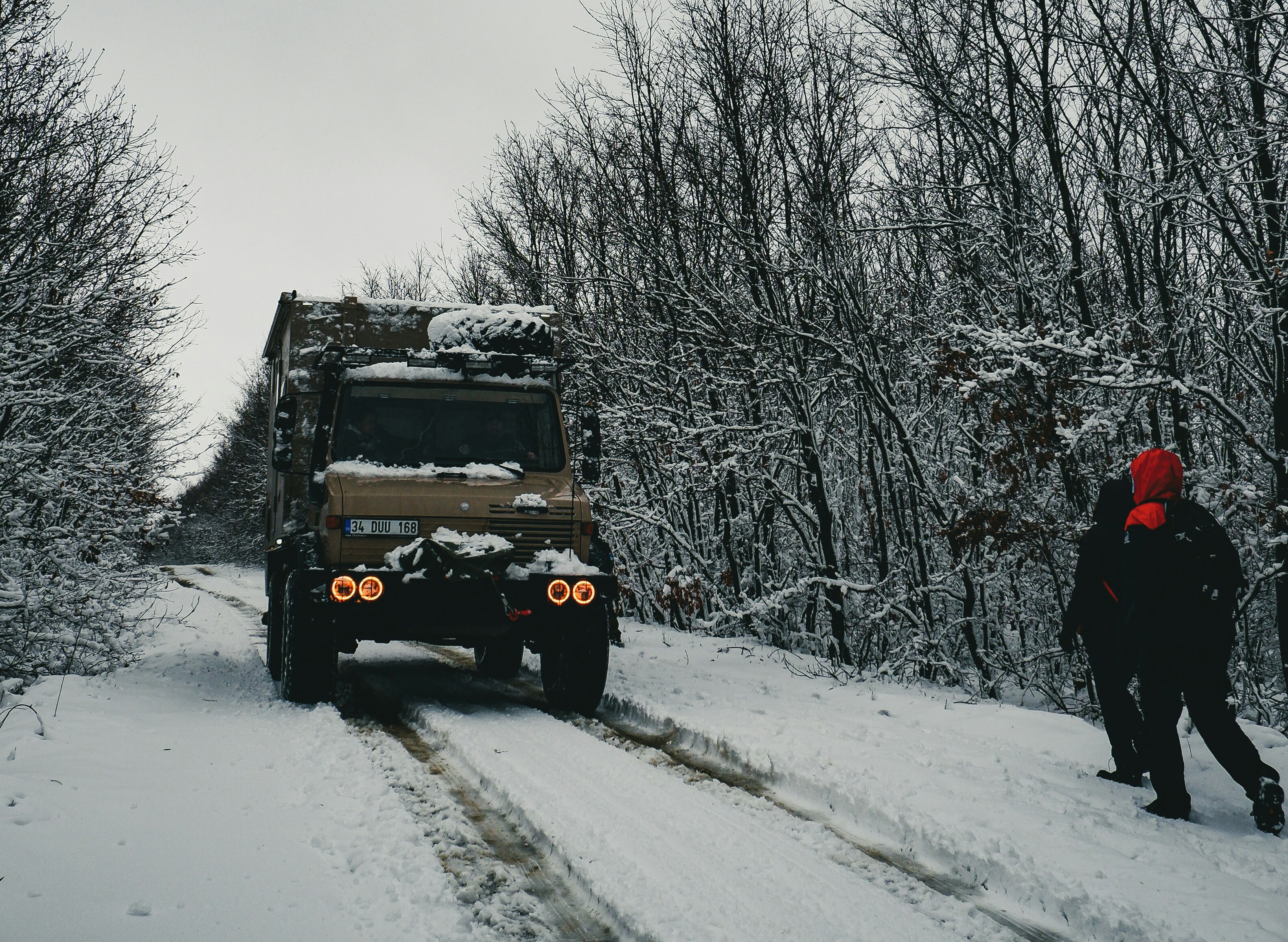 Snowbound Standoff: A Truck Treads Through White Silence