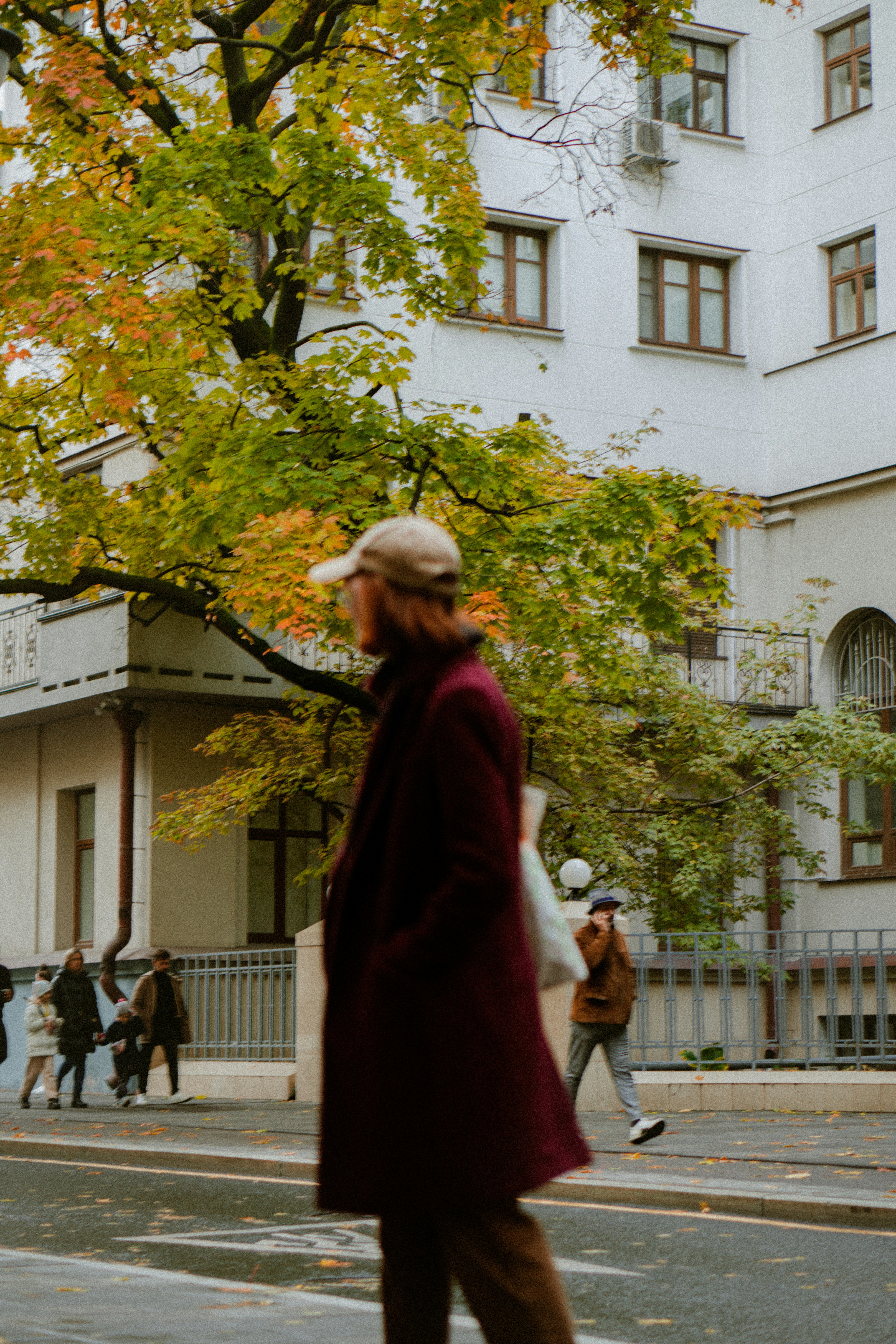 Autumn in Motion: Burgundy Coat on a Quiet City Street