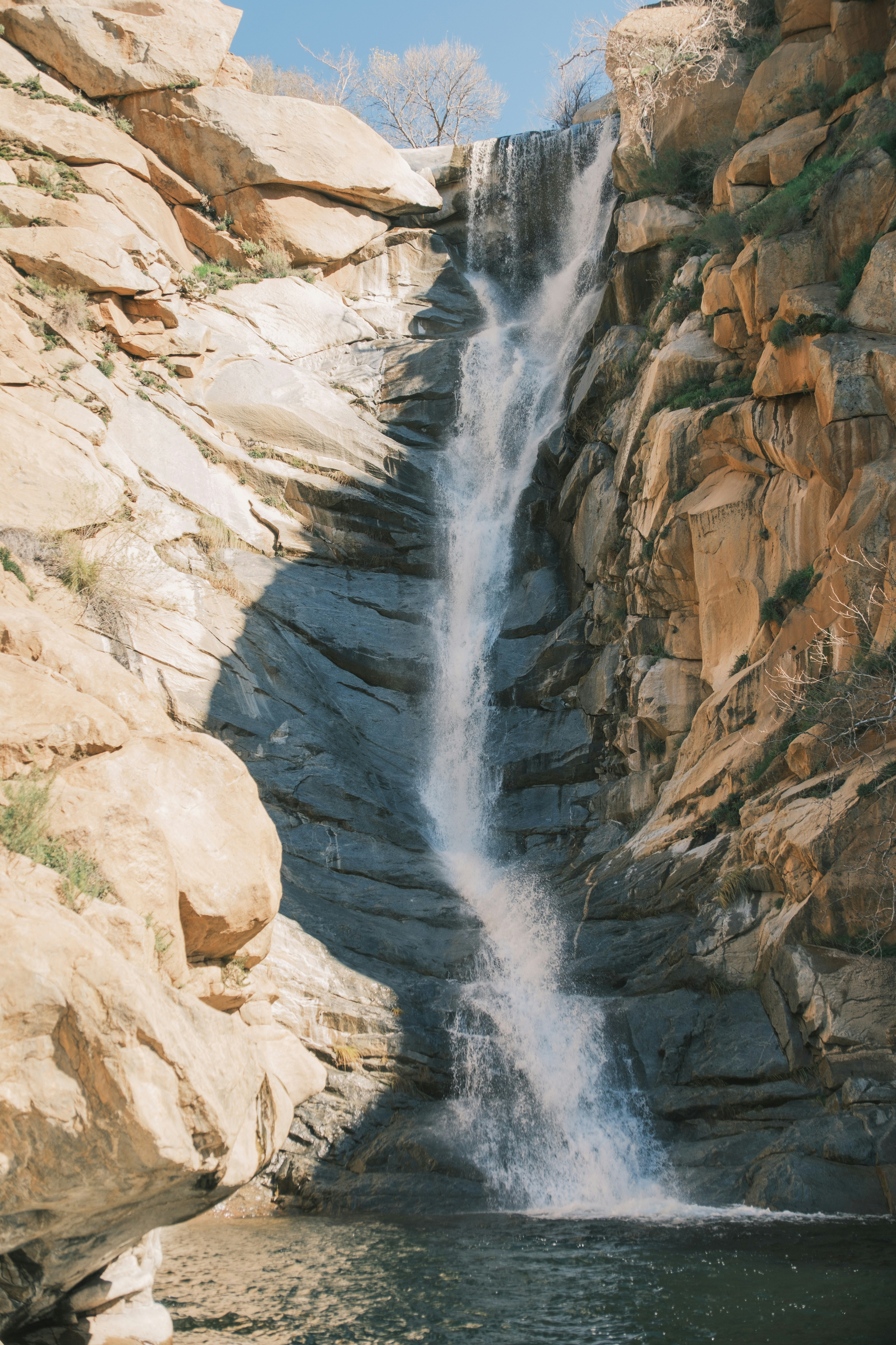 Granite Veil: A Narrow Canyon Waterfall Framed by Sunlit Cliffs