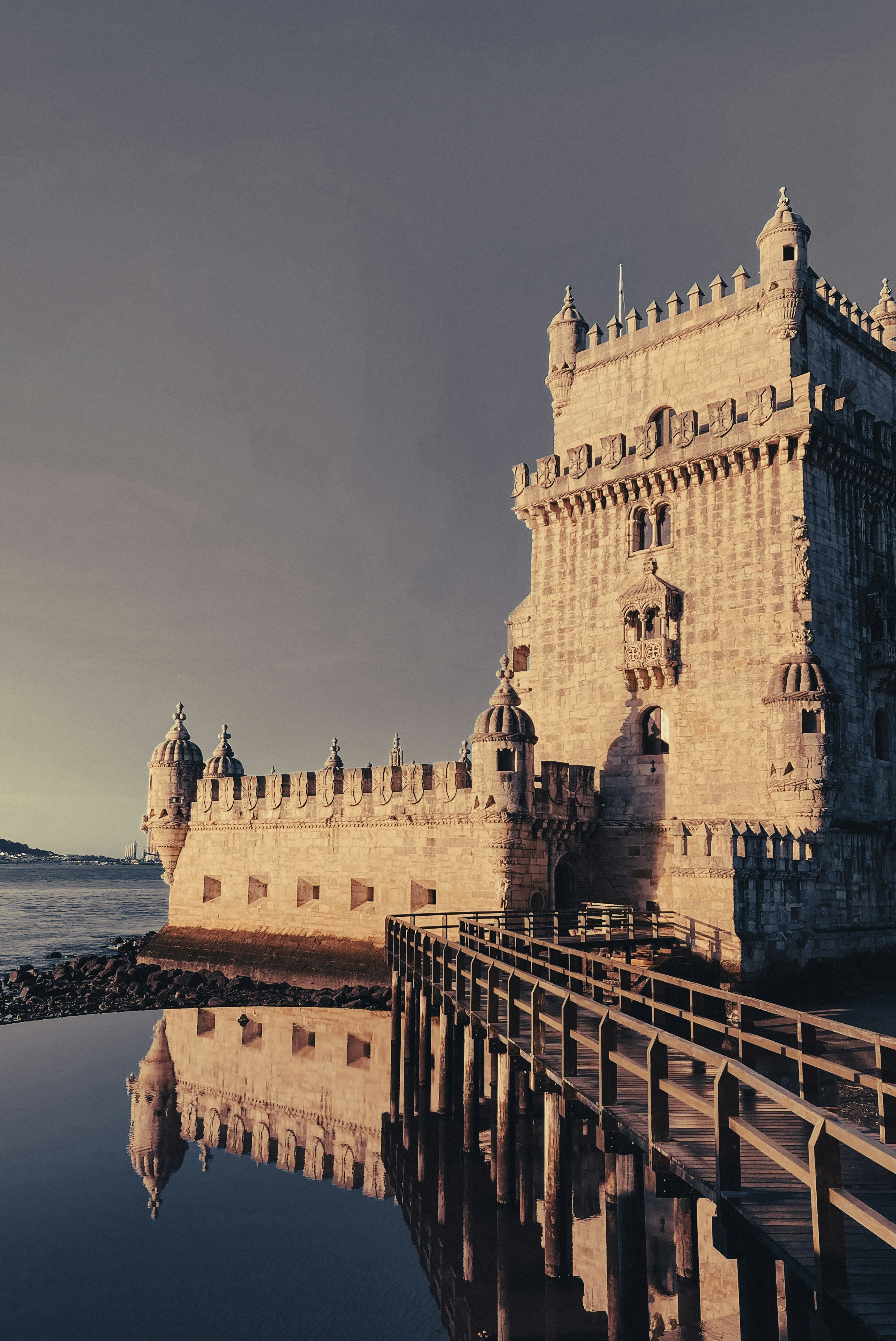 Golden Hour Fortress Over Calm Waters: A Coastal Castle and Its Reflective Walkway