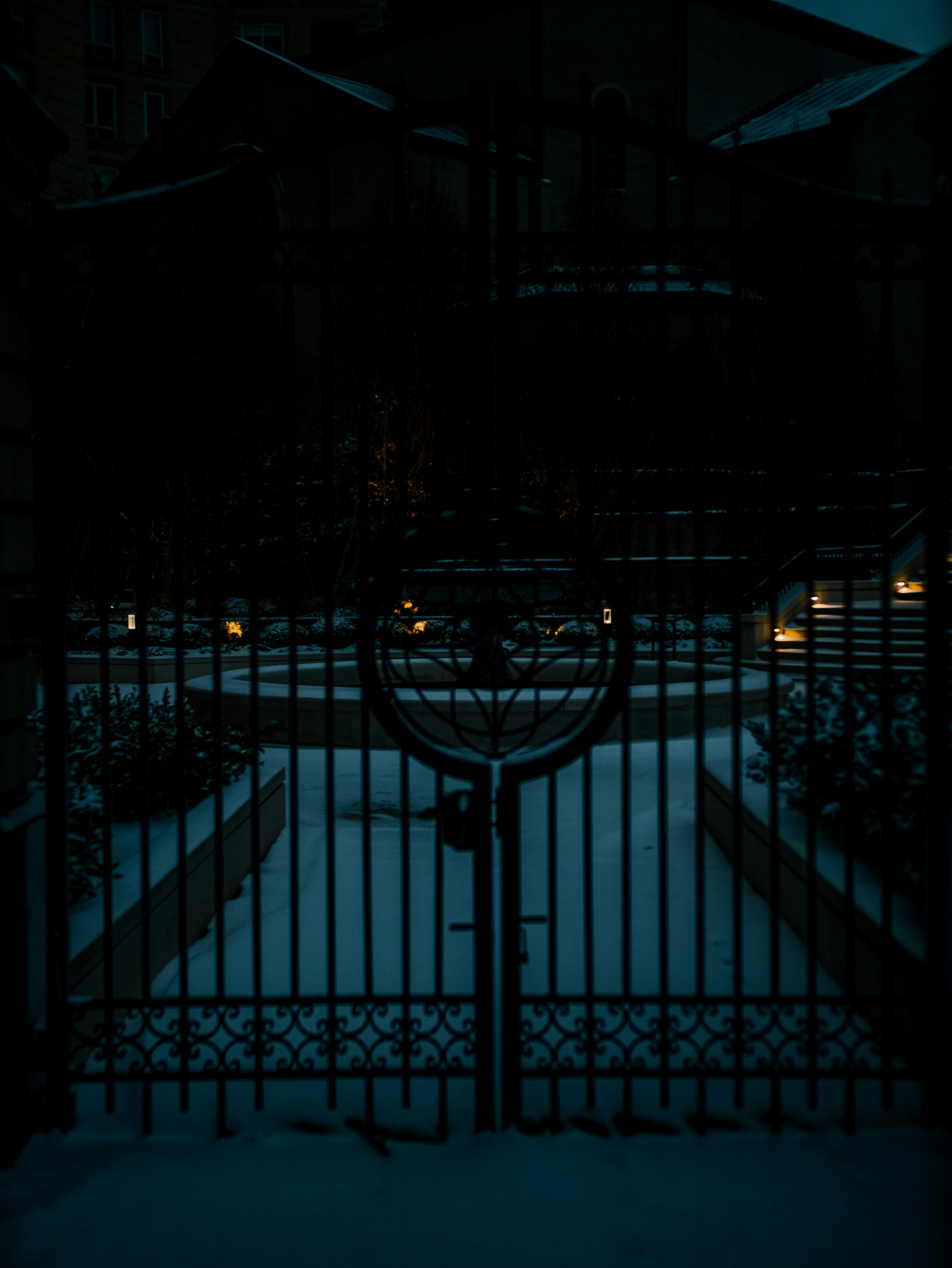 a gate with a snow covered street in the background