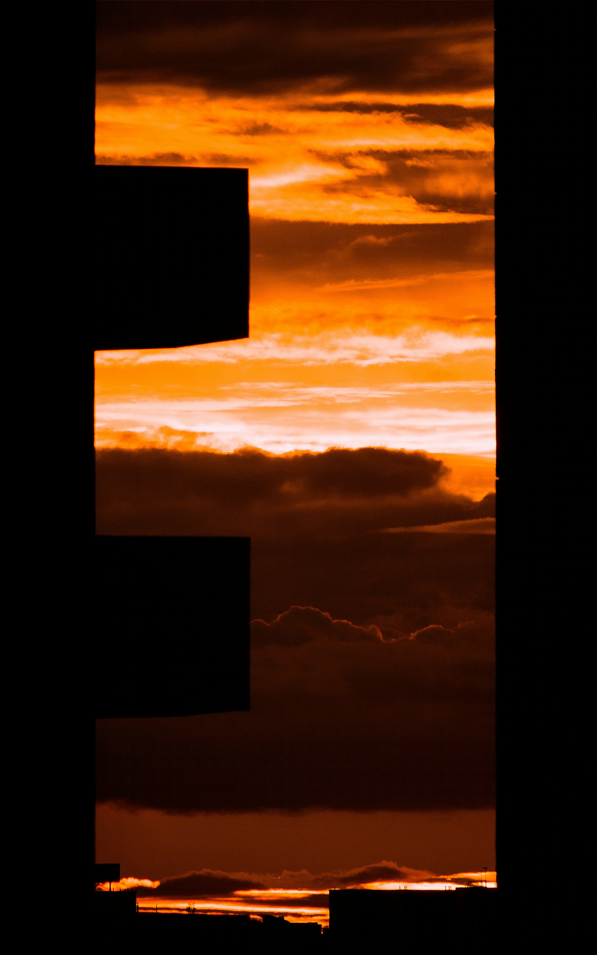 Vertical Cut: Fiery Sunset Framed by Architectural Silhouettes