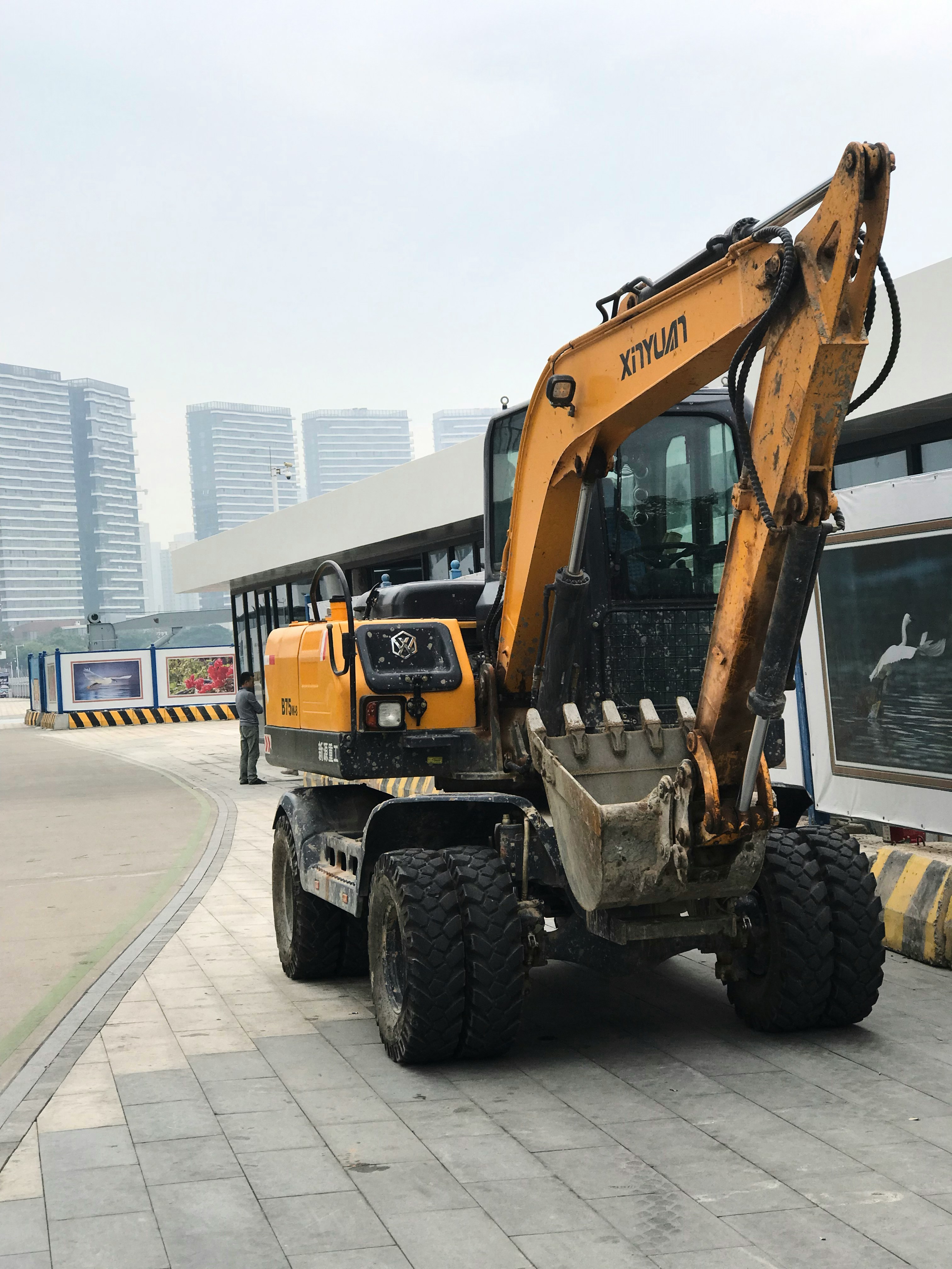 A construction vehicle is parked in front of a bus photo – Free ...