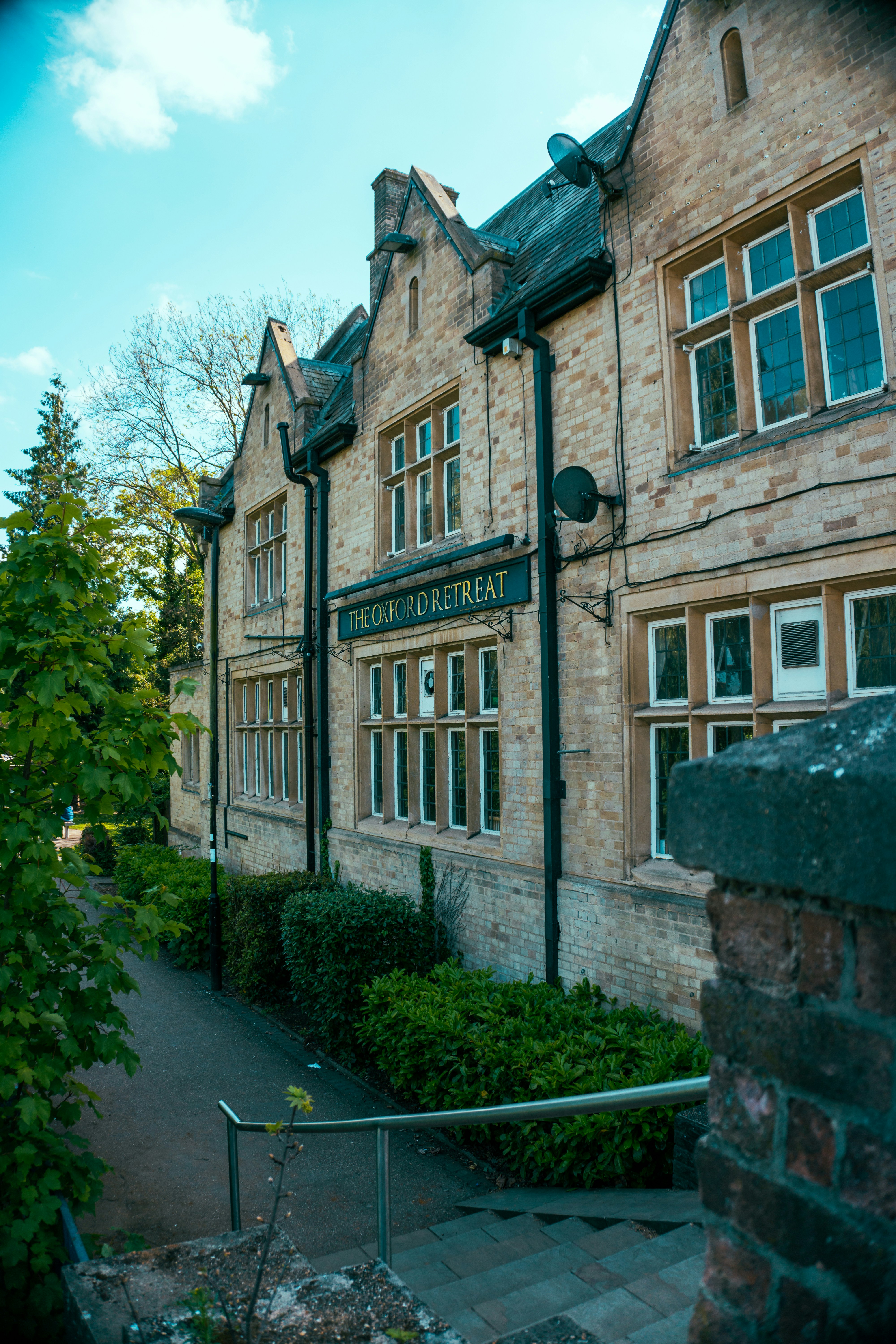 The Old Retreat Facade: Sunlit Brick and Greenery