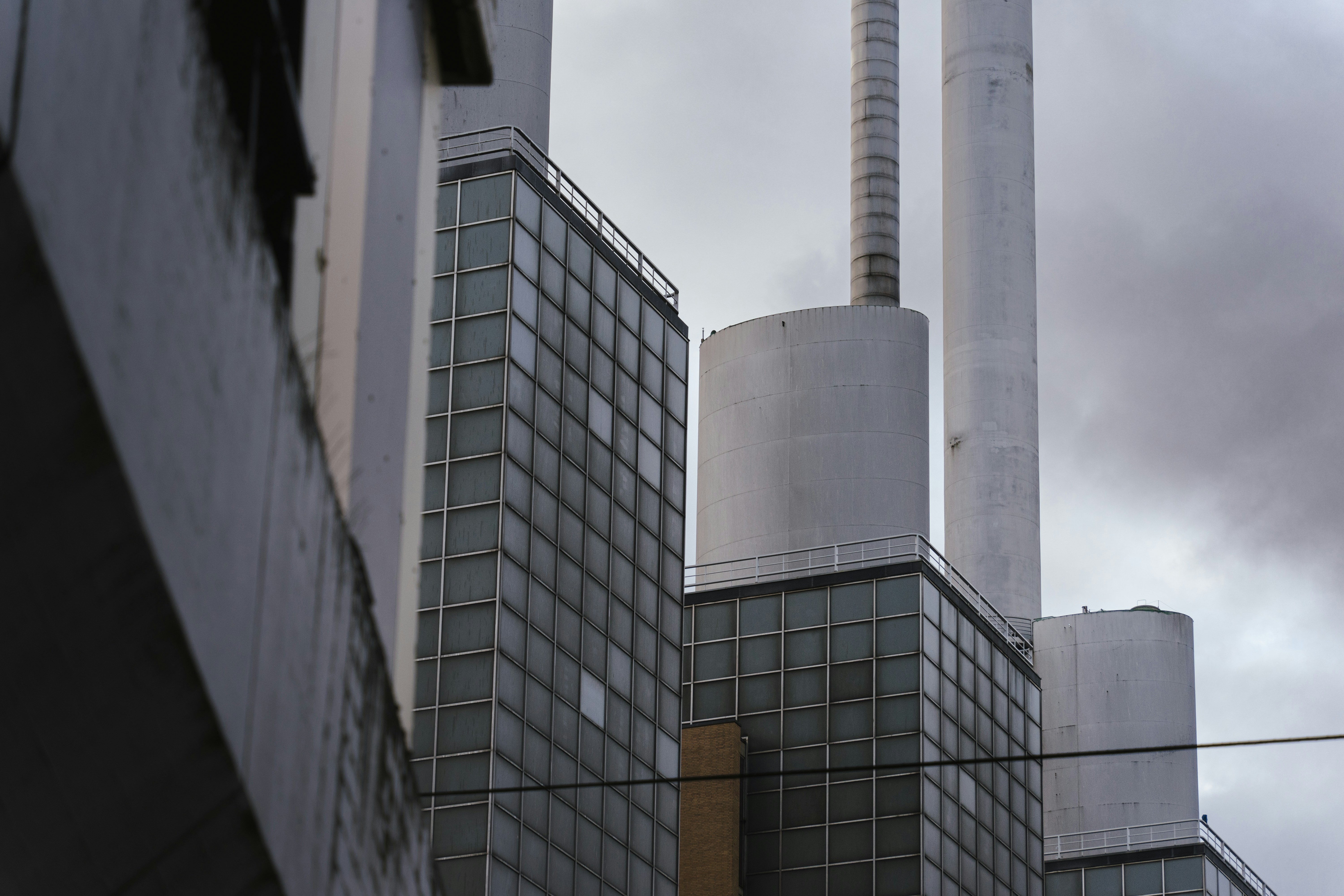 A tall building with two smoke stacks next to it photo – Free ...