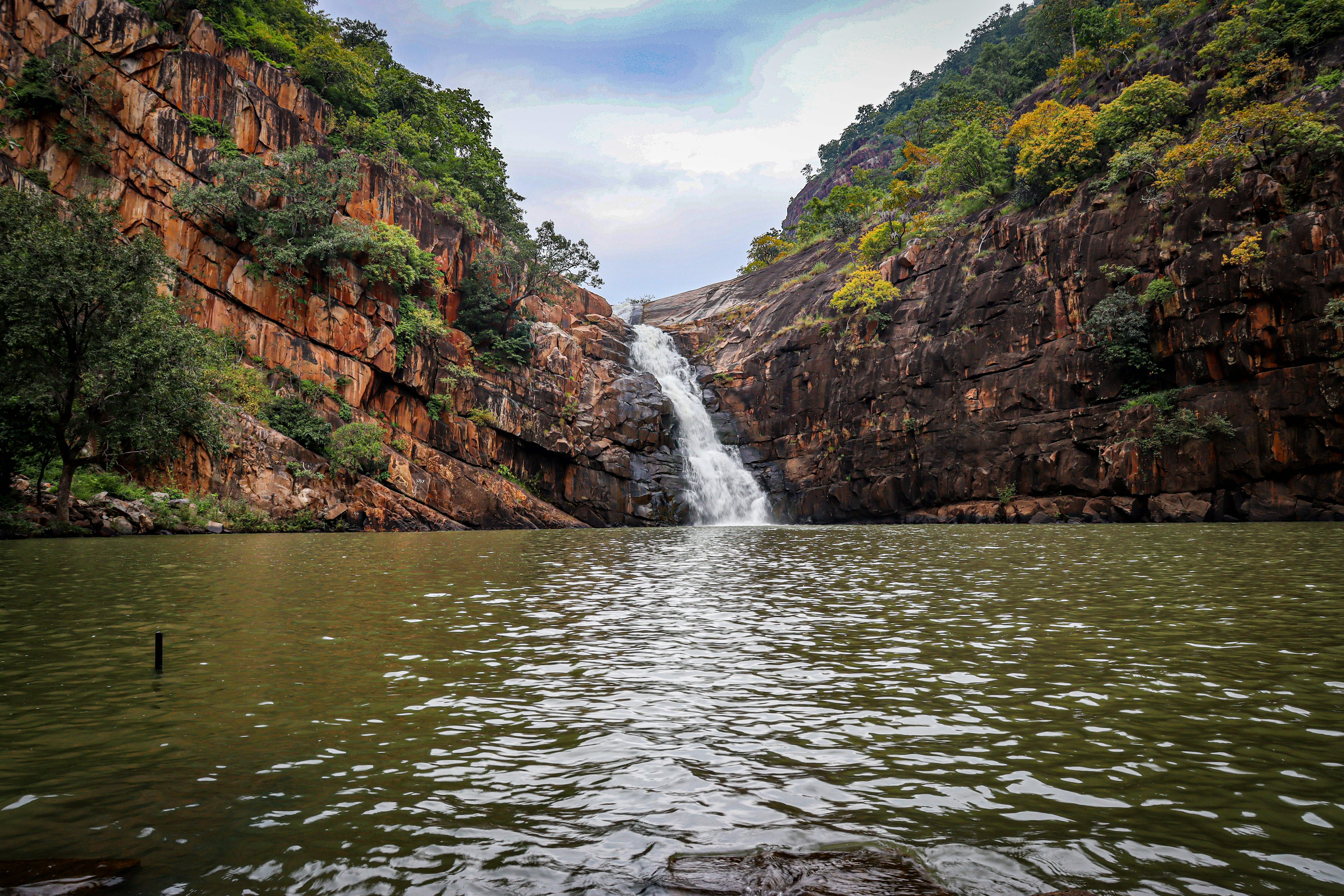A large waterfall in the middle of a body of water photo – Free Nemali ...