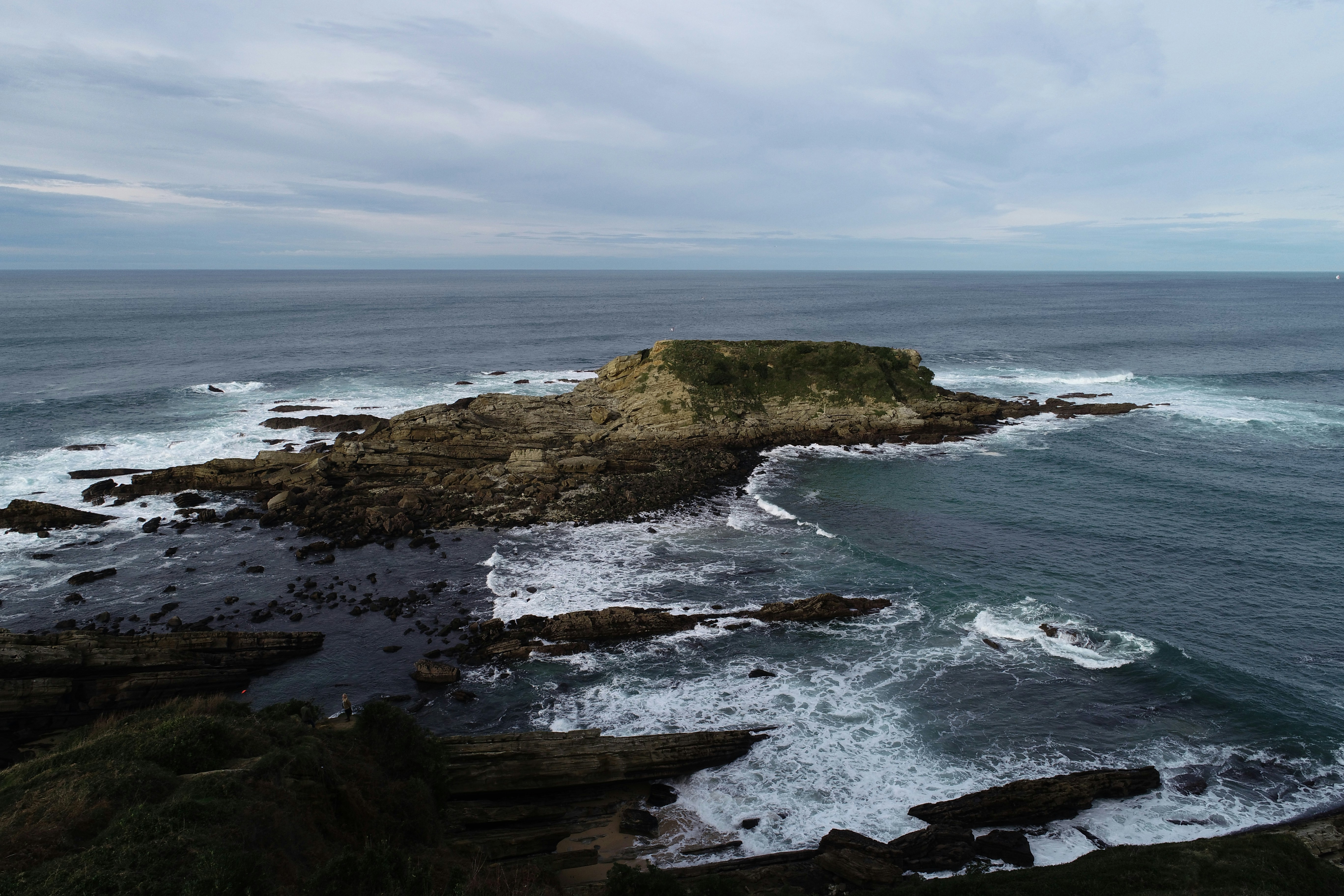 a large body of water next to a rocky shore