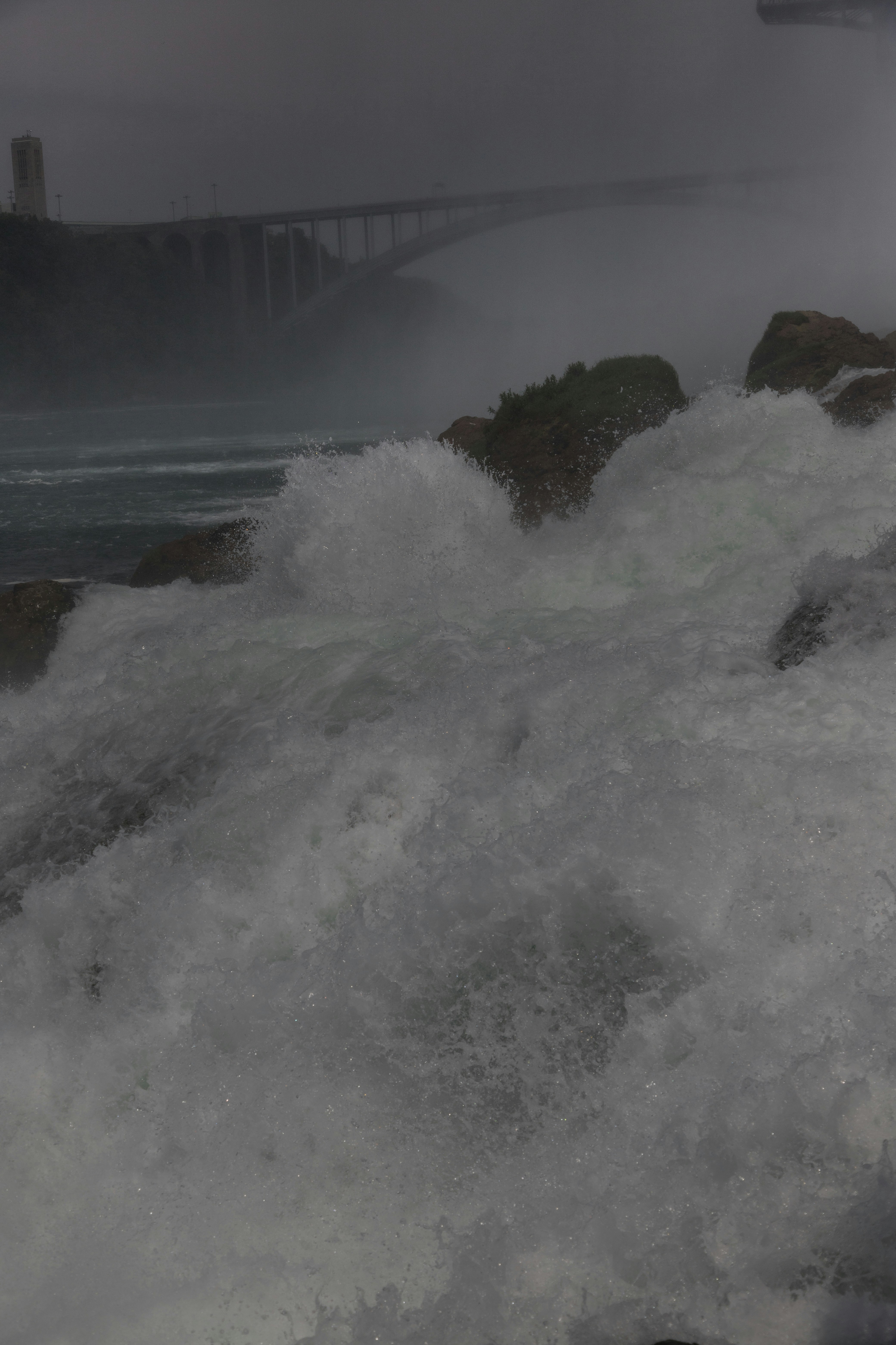 Rushing Fjord: Cascade of Foam Beneath a Grey Skyline