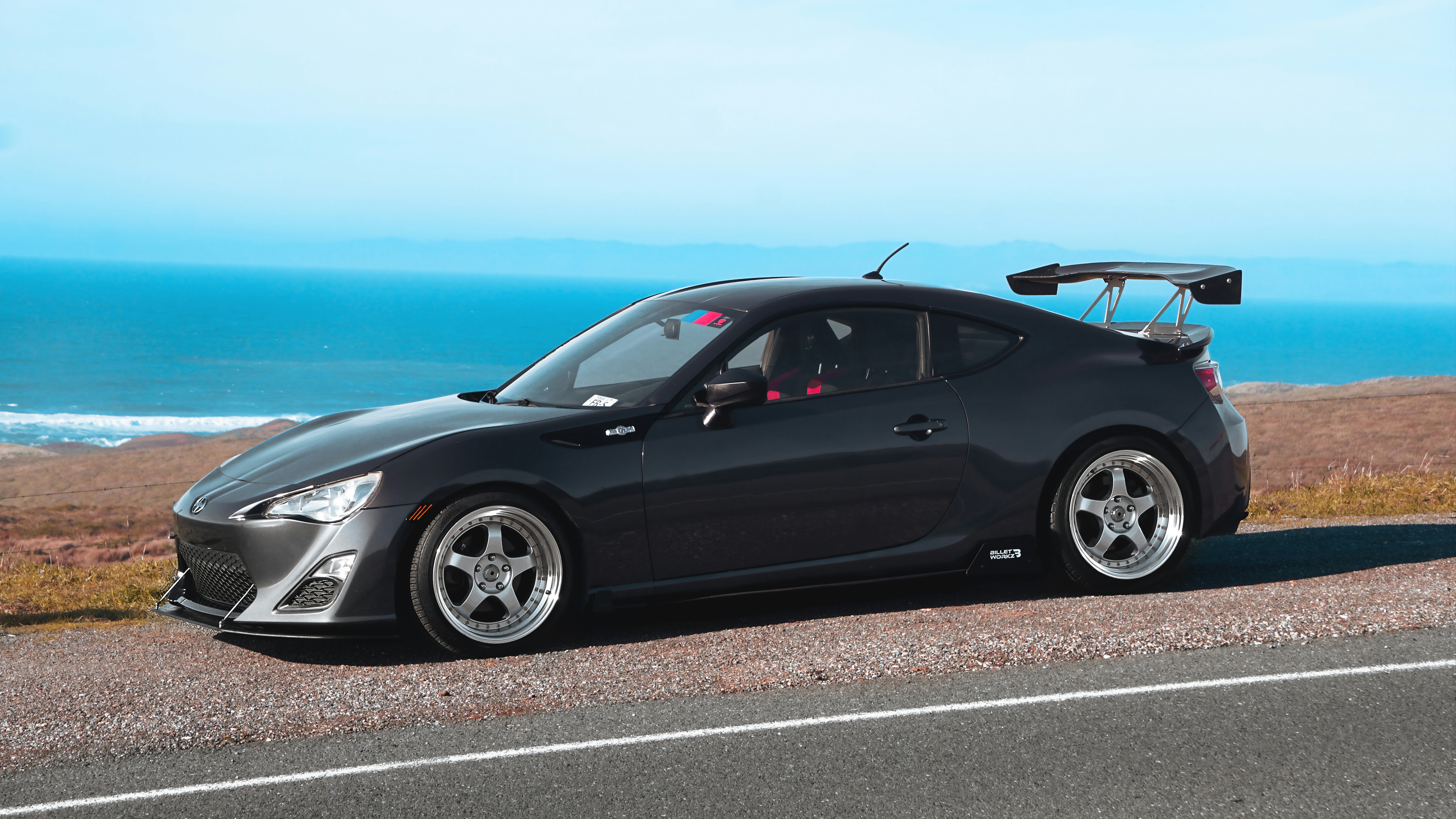 Coastal Wing: A Black Sport Coupe with a Dominant Rear Wing