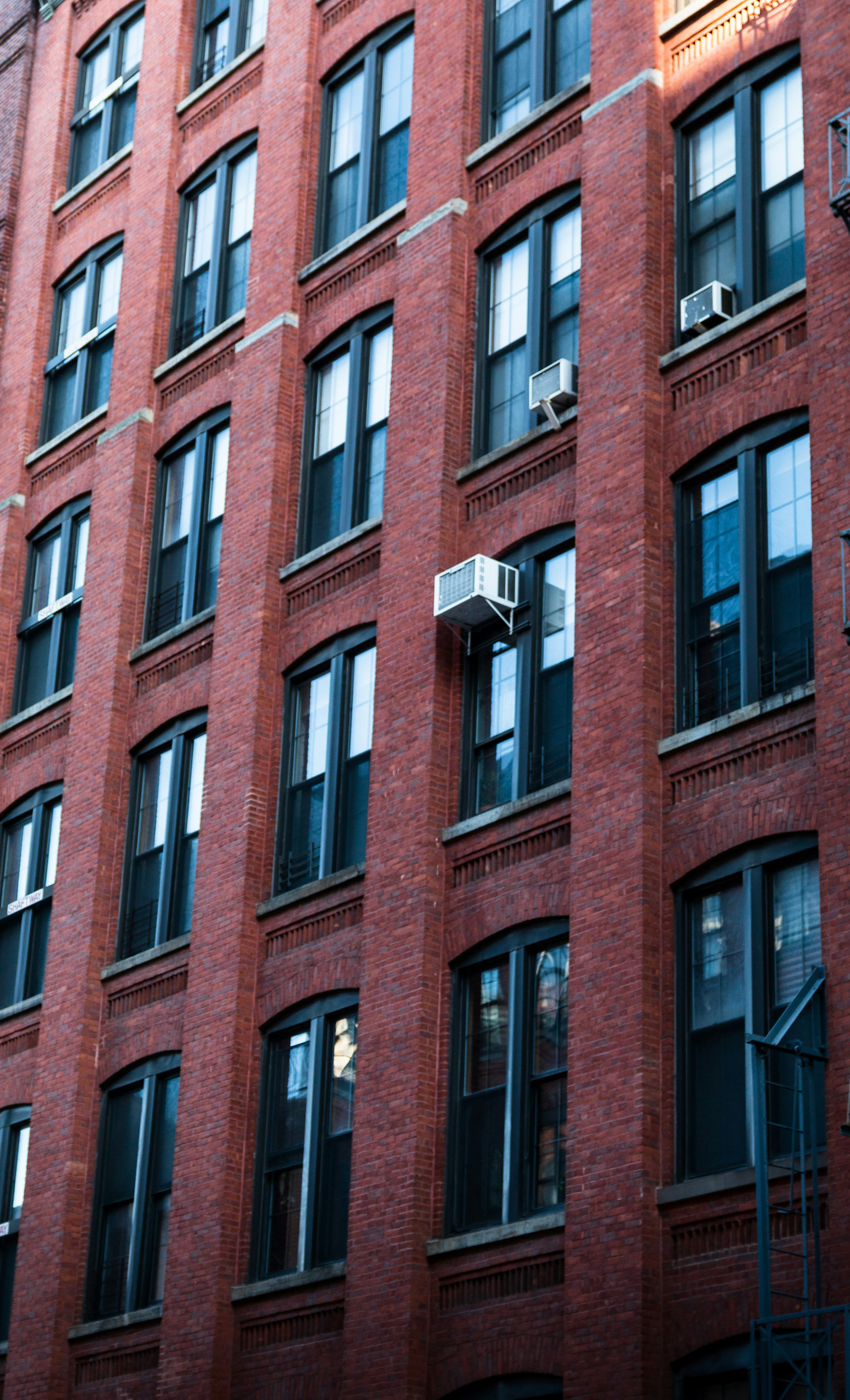 Foto Un alto edificio de ladrillo rojo con muchas ventanas – Imagen Nueva York gratis en Unsplash