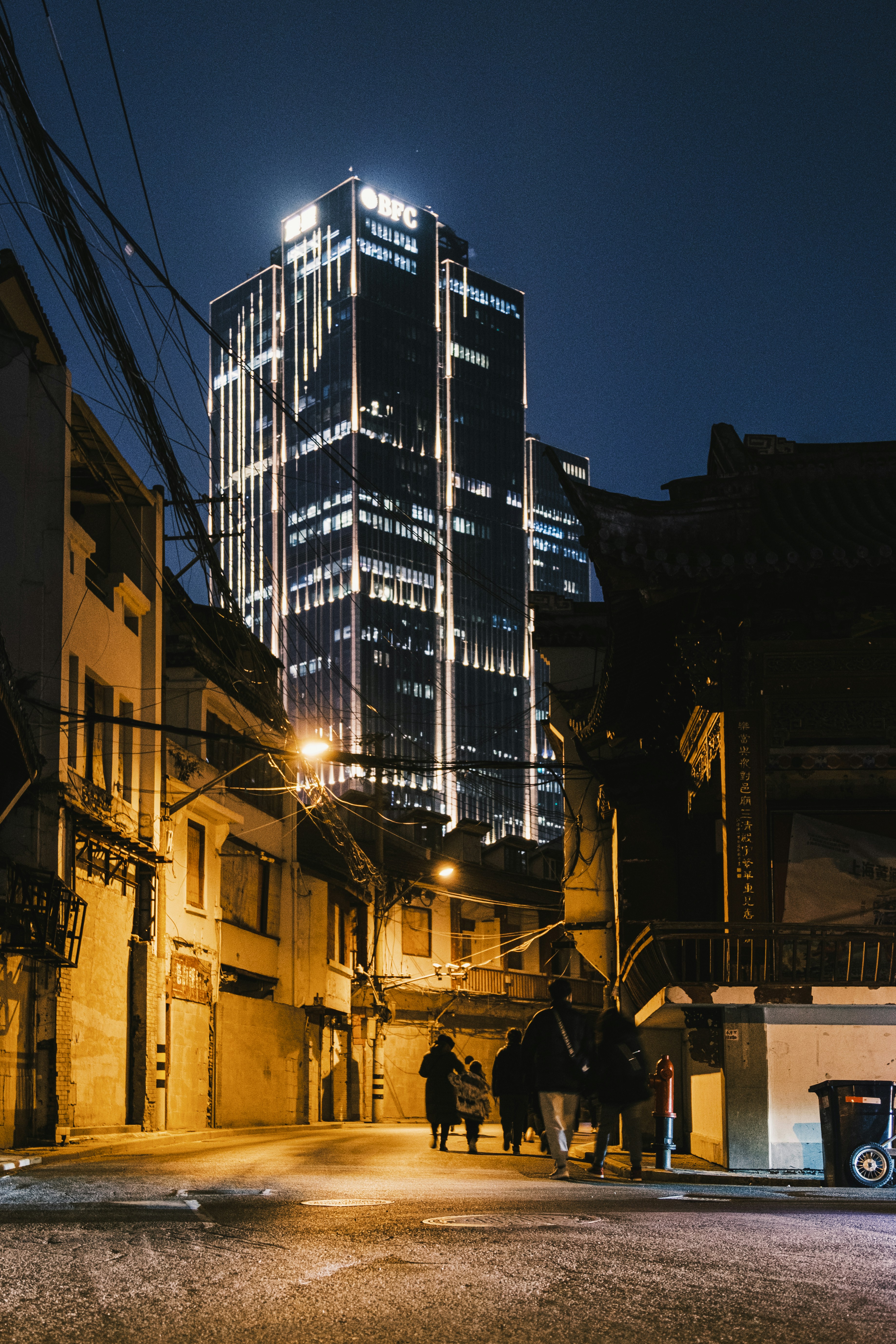 a group of people walking down a street at night