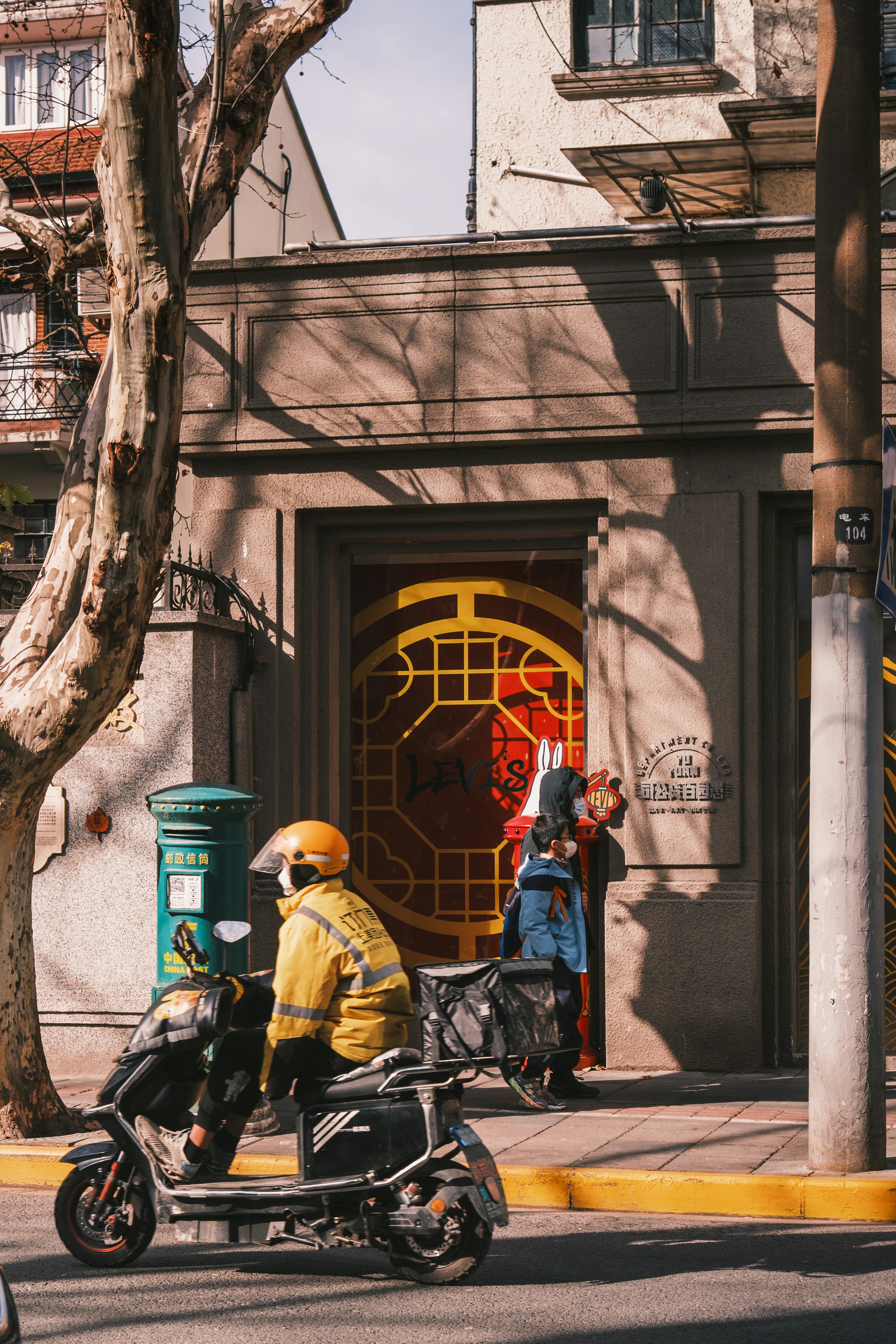 Yellow-helmeted Rider at a Shaded Urban Entrance