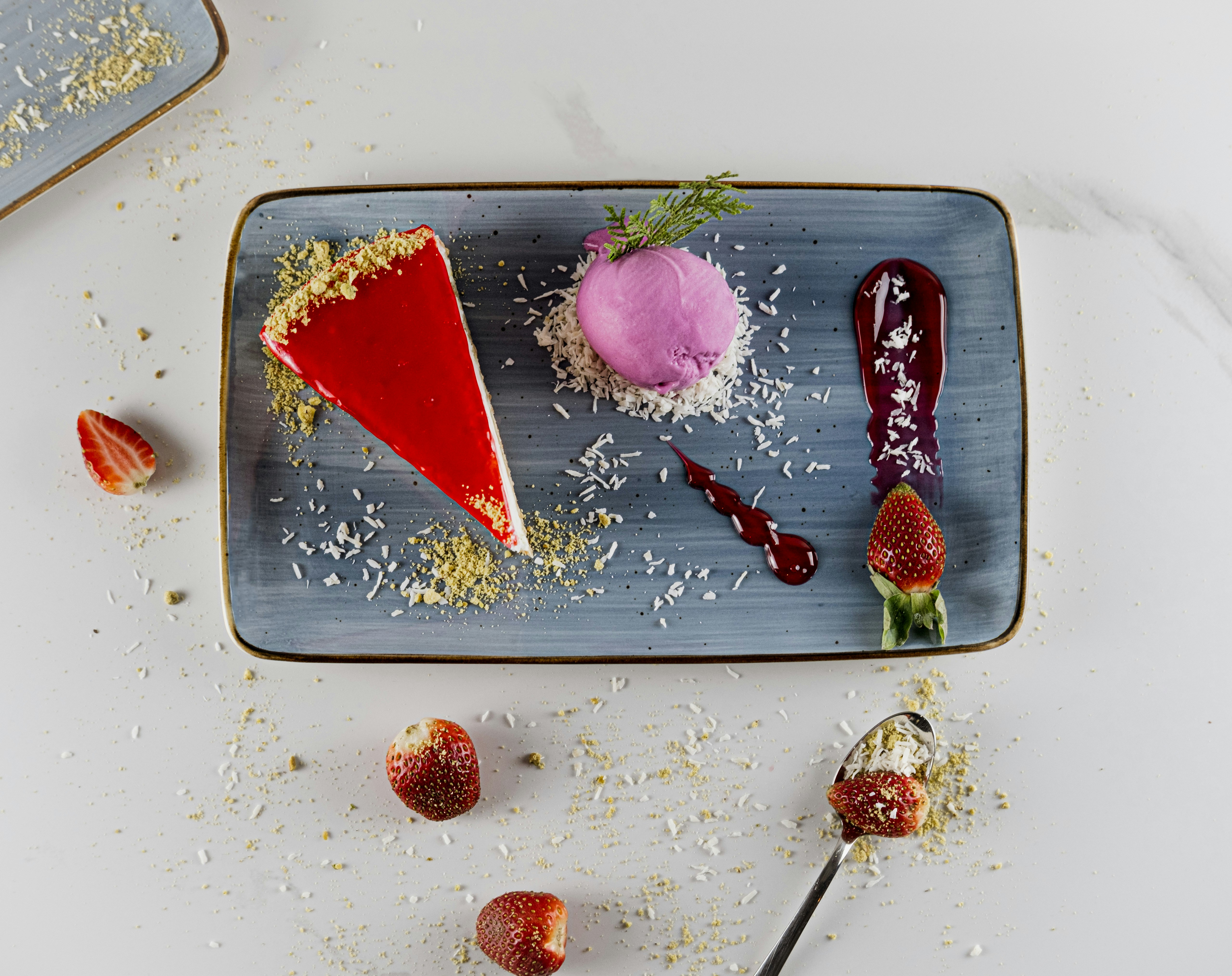A Gallery Plate of Modern Desserts: Red Slice, Pink Sphere, and a Gleaming Drizzle