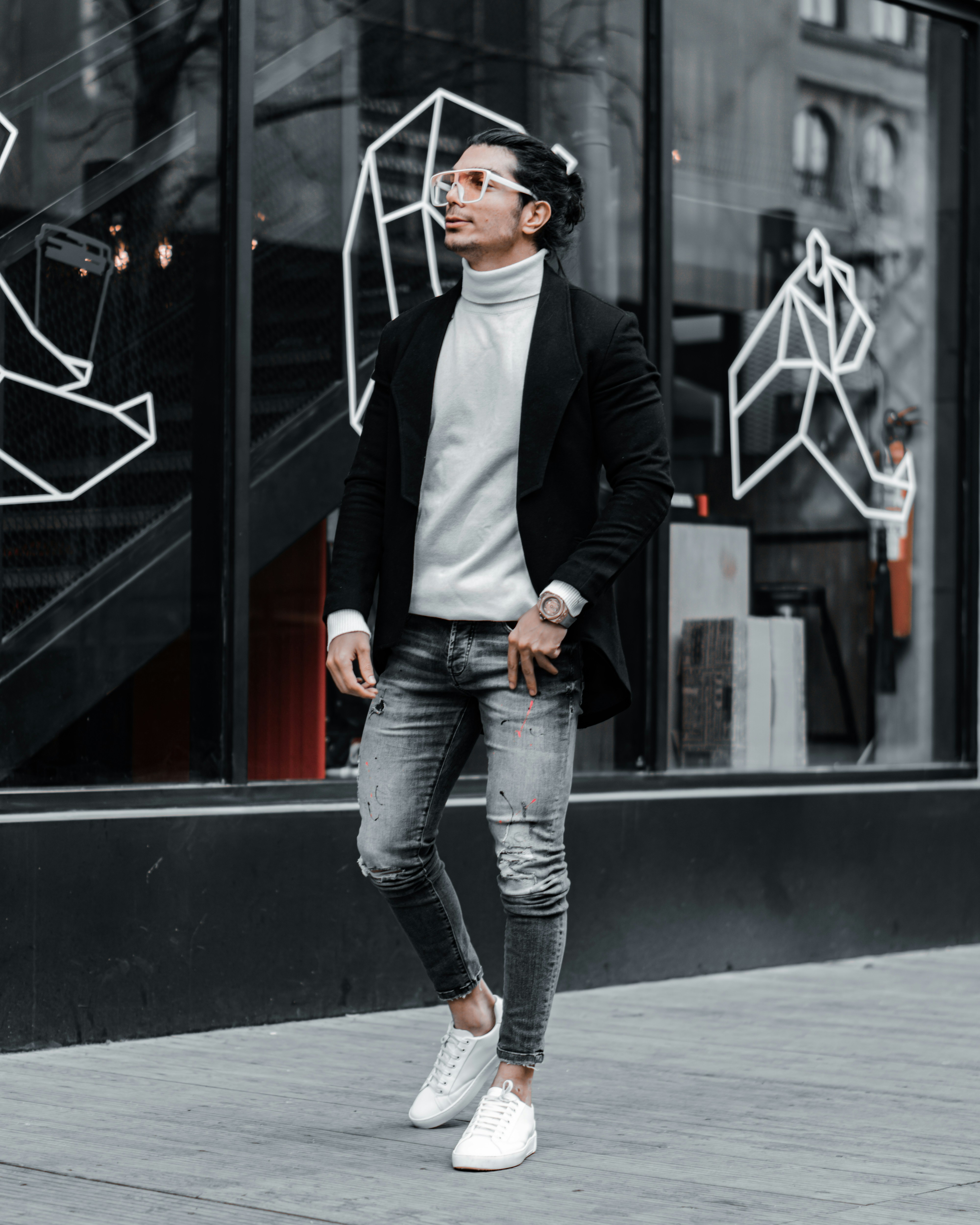 A man standing on a sidewalk in front of a building photo – Free ...