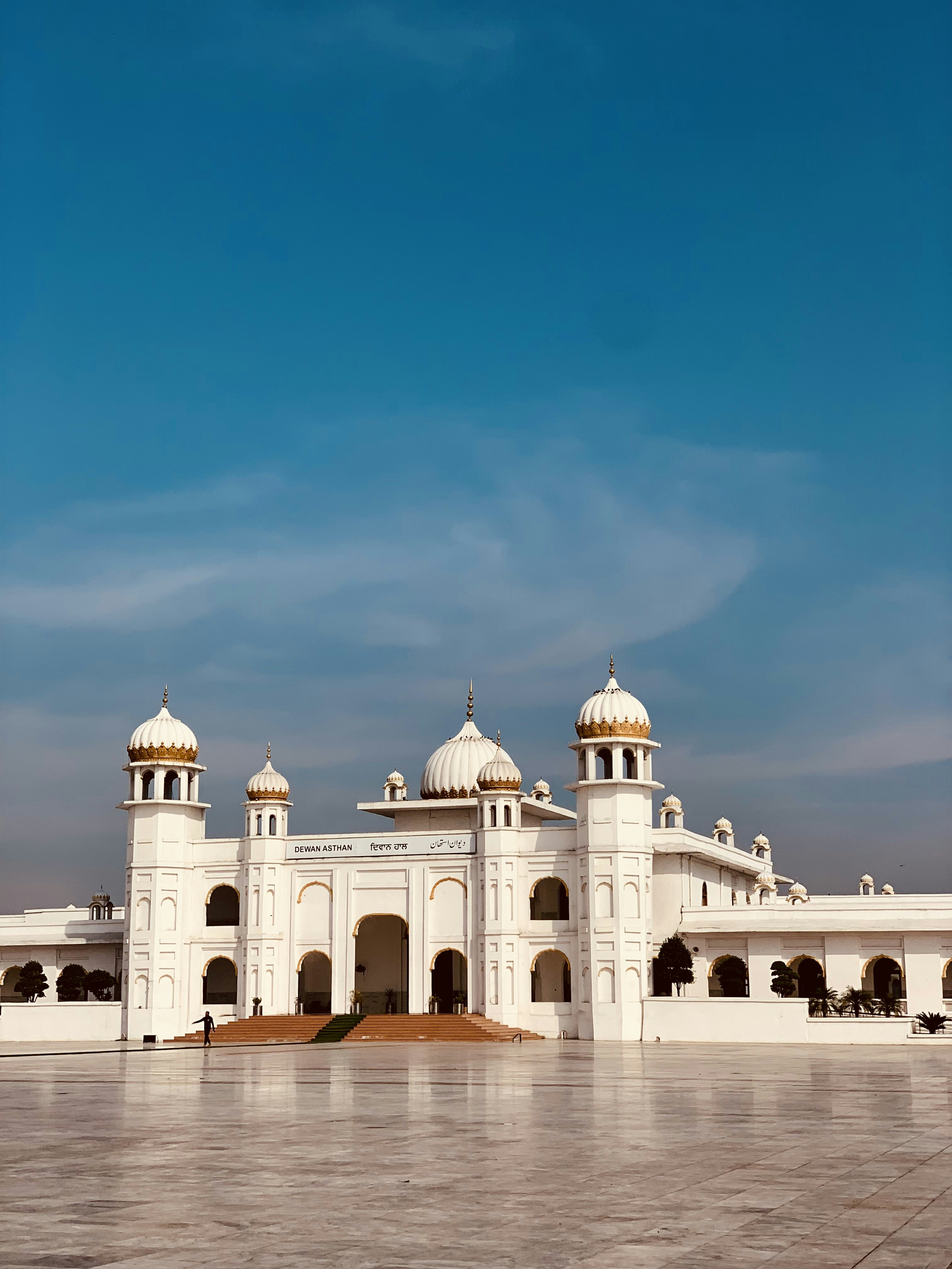 A large white building sitting on top of a cement field photo – Free ...