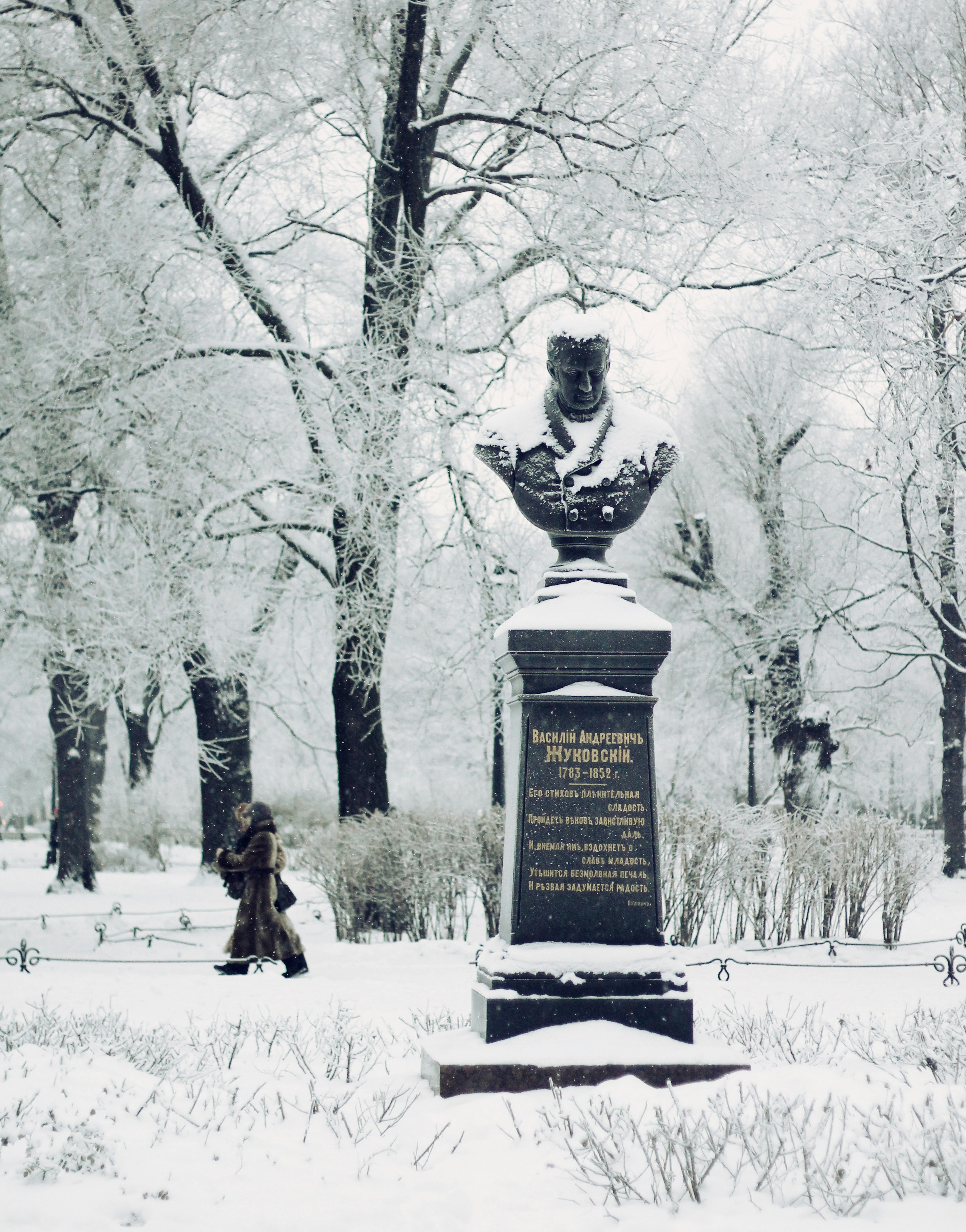 A statue in a snowy park with trees in the background photo – Free ...