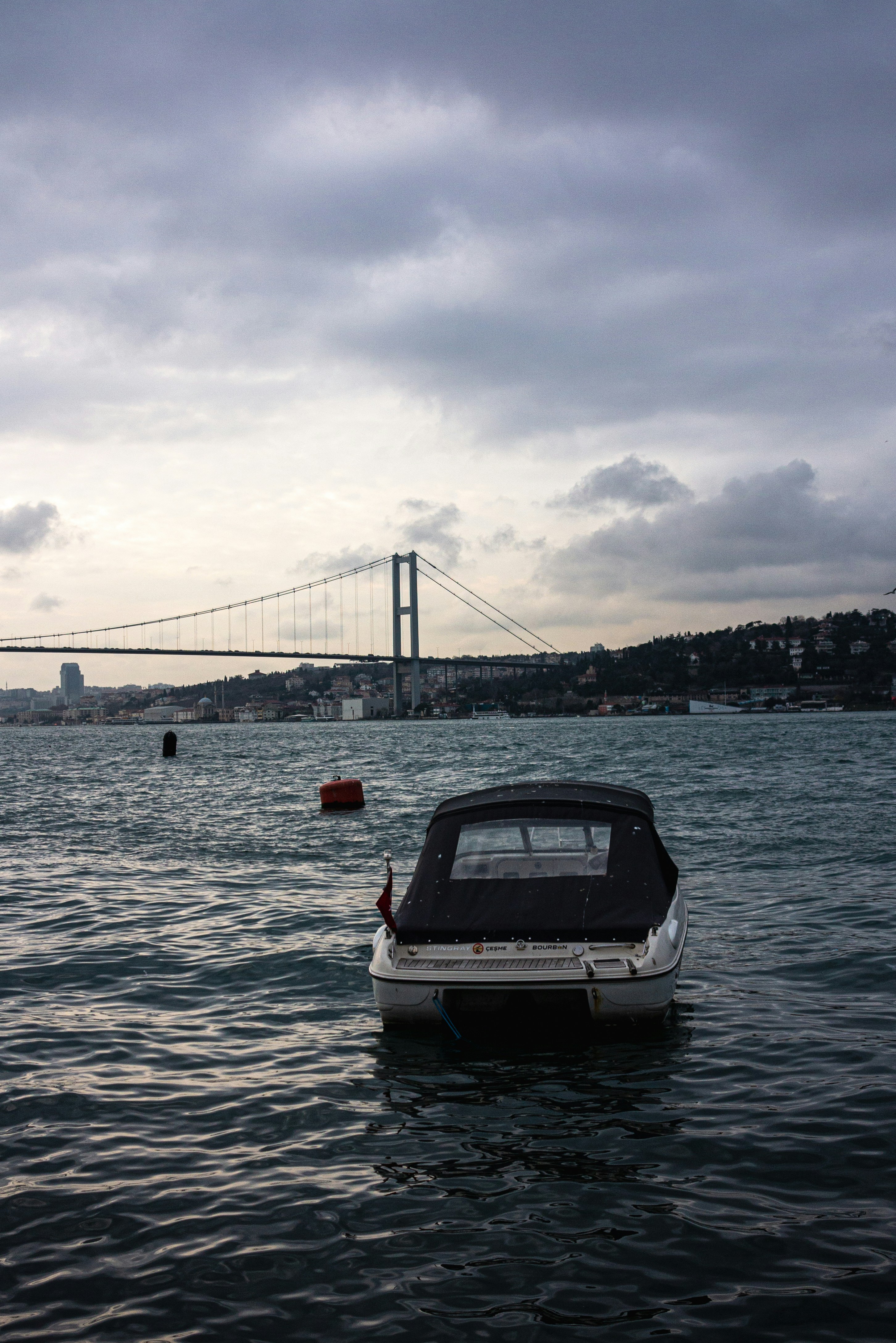 Dusk at the Dock: A White Yacht Anchored Before a Looming Cable-Stayed Bridge
