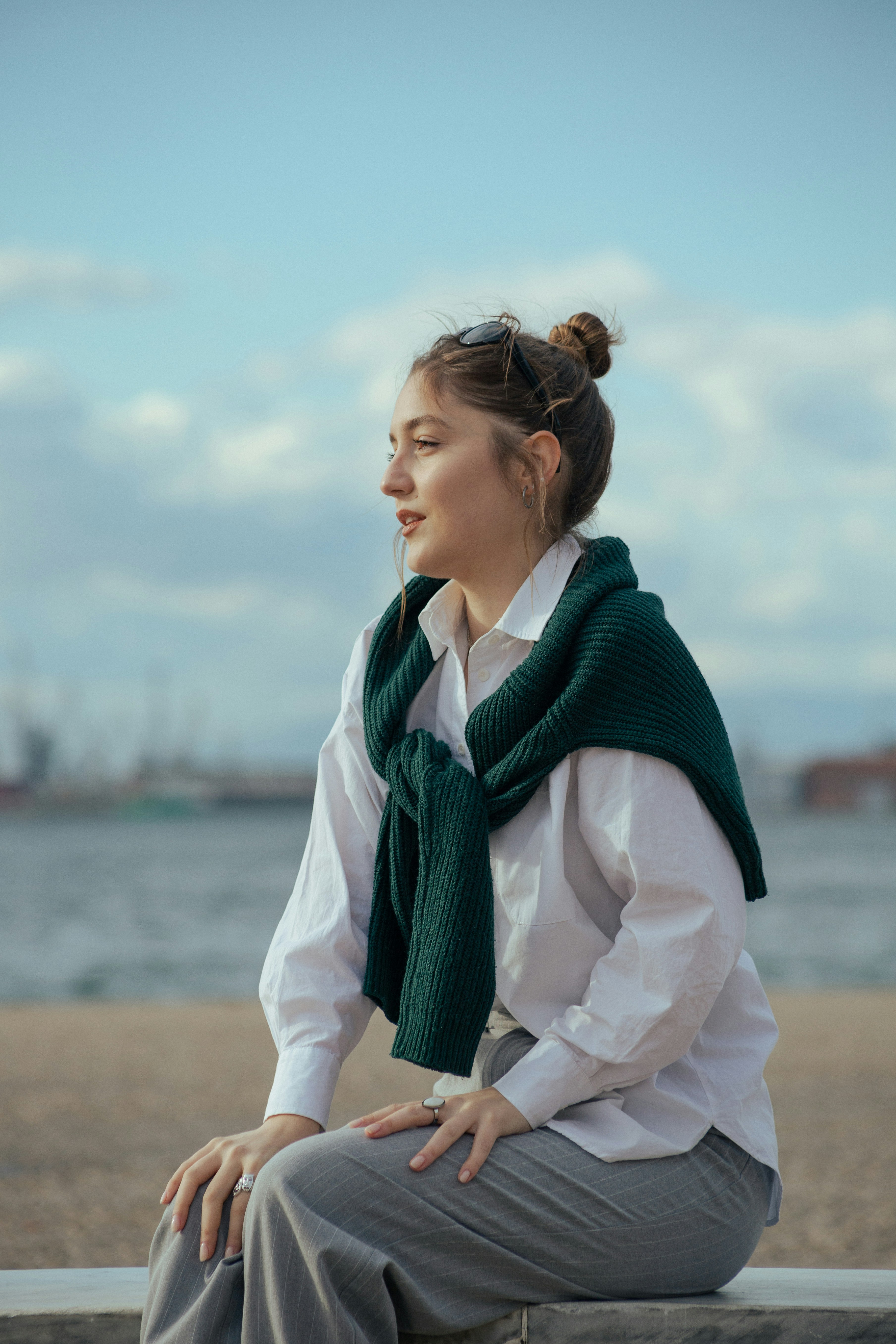 A woman wearing a green scarf sitting on a bench photo – Free Girl ...