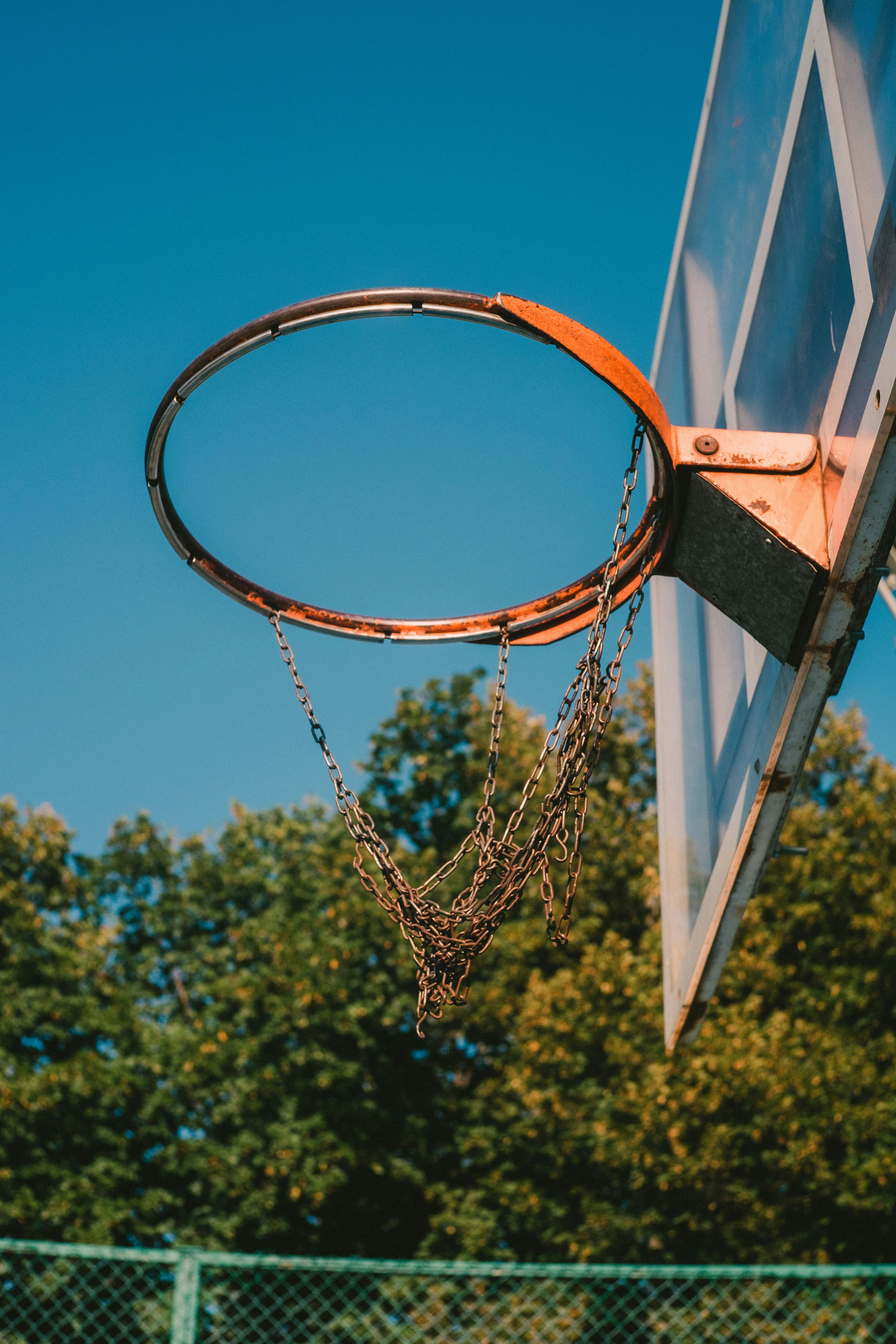A basketball hoop with chains hanging from it photo – Free Basketball ...
