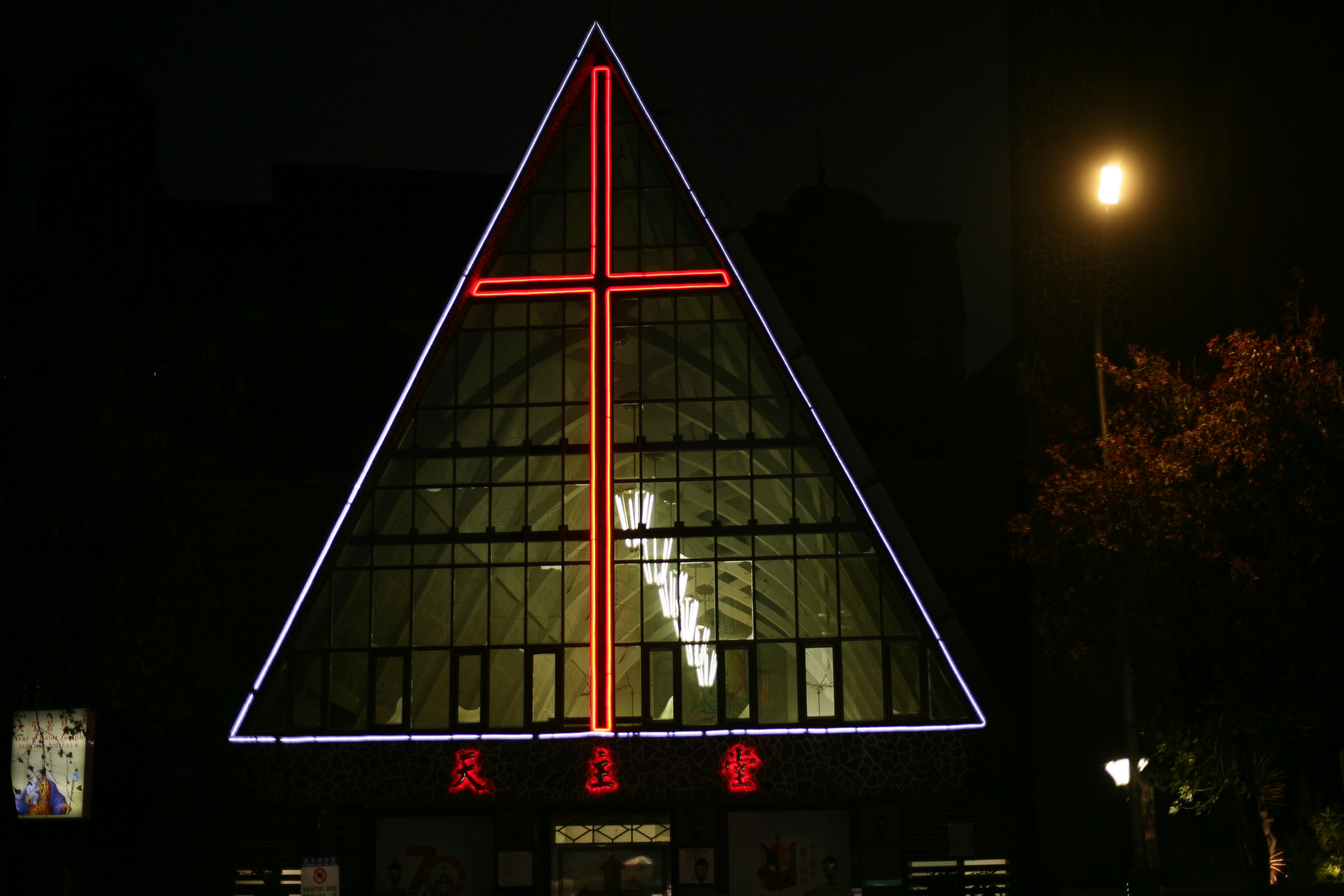 a building with a lit up cross on top of it