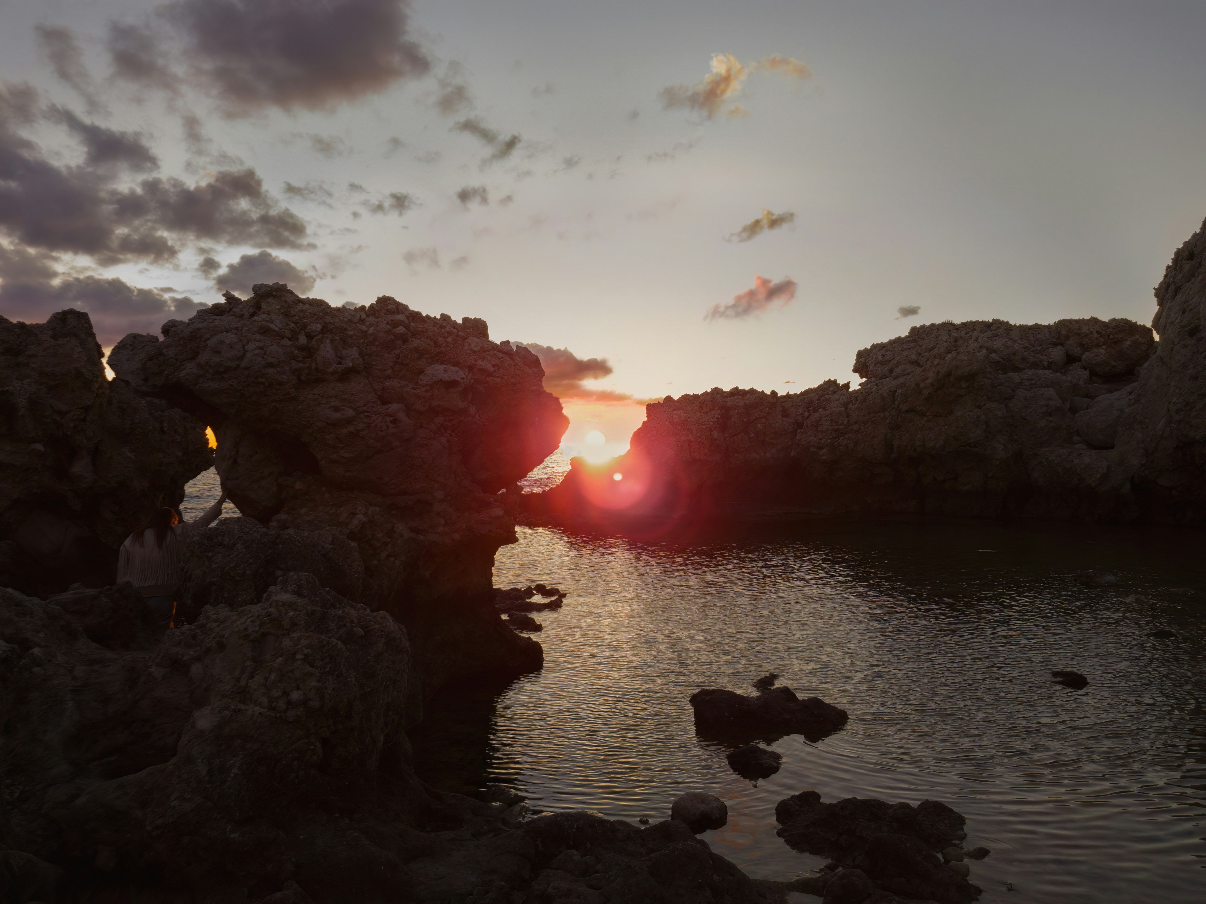 Sunset Through a Weathered Sea Arch: Quiet Waters and Timeworn Rocks