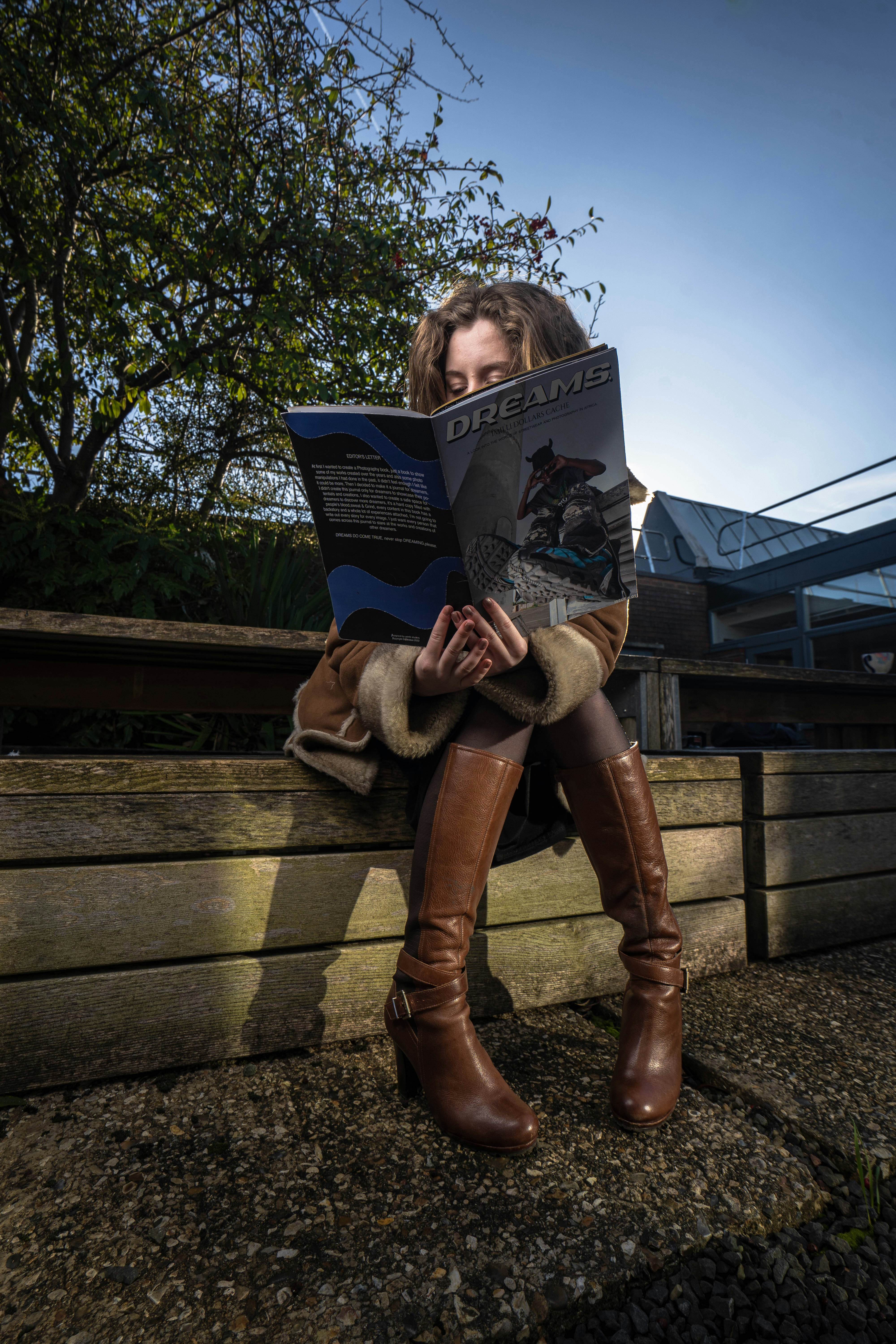 A woman sitting on a bench reading a book photo – Free Winter Image on ...