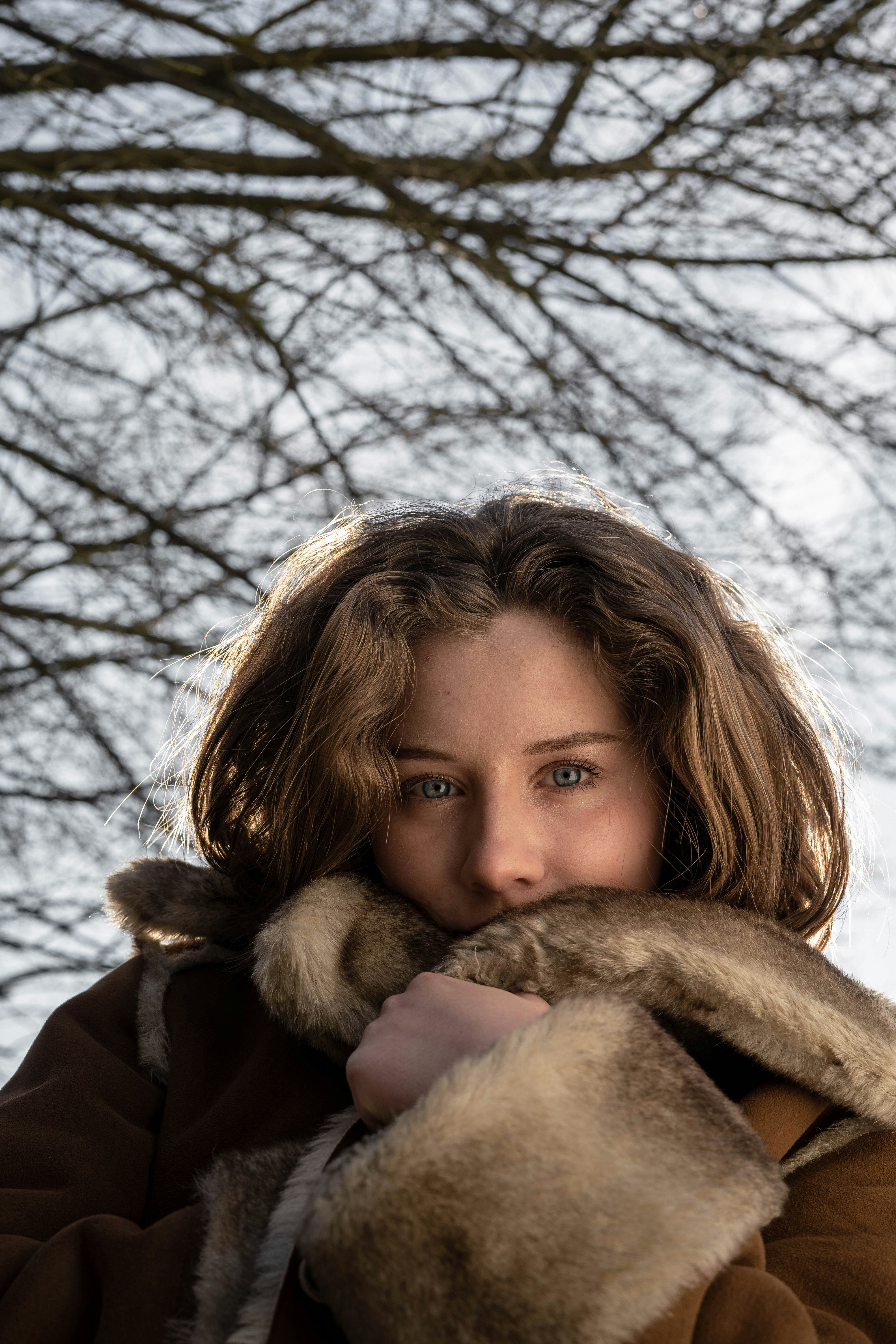 Winter Whisper: A Portrait Framed by Bare Branches