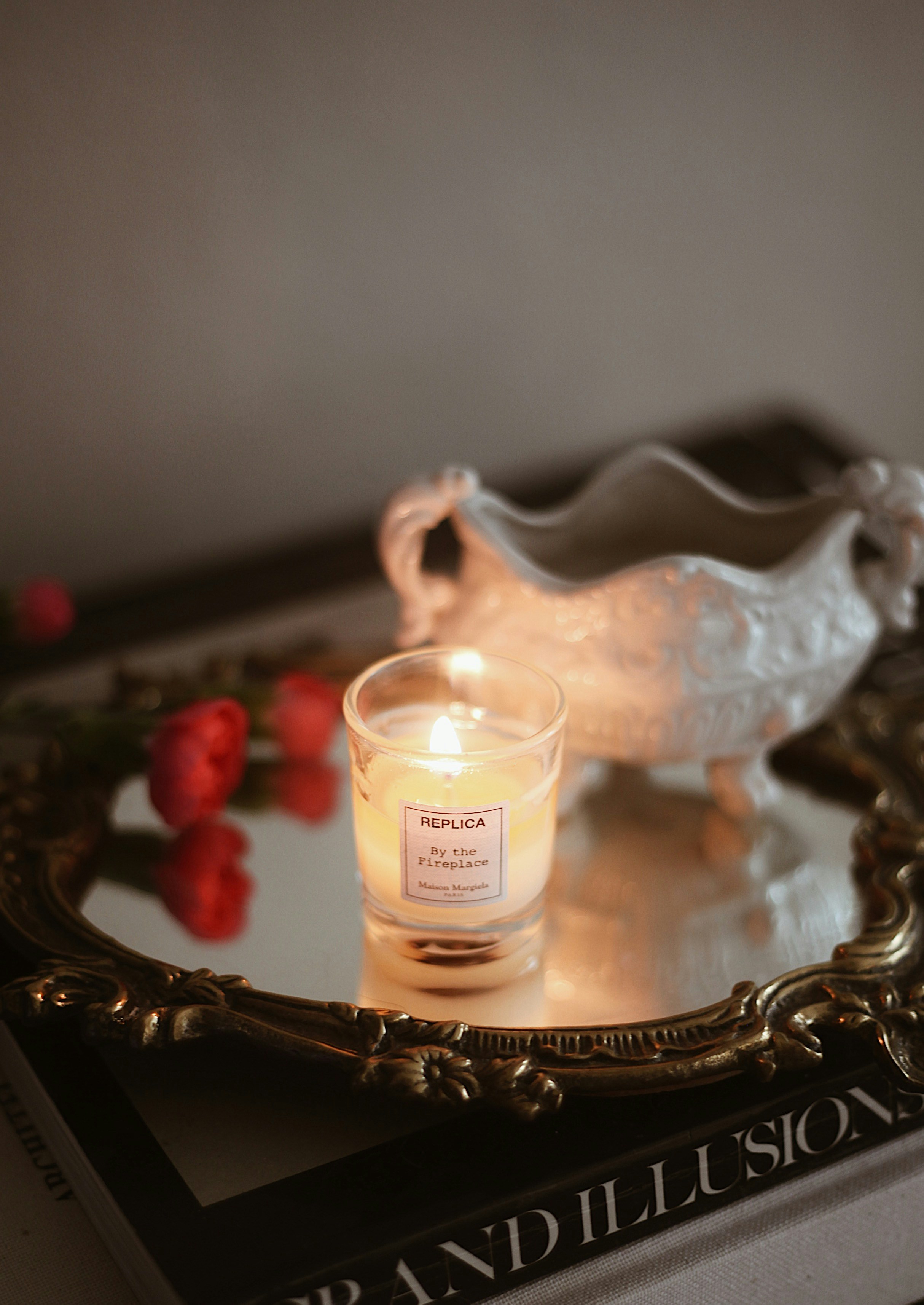 a candle sitting on top of a table next to a mirror
