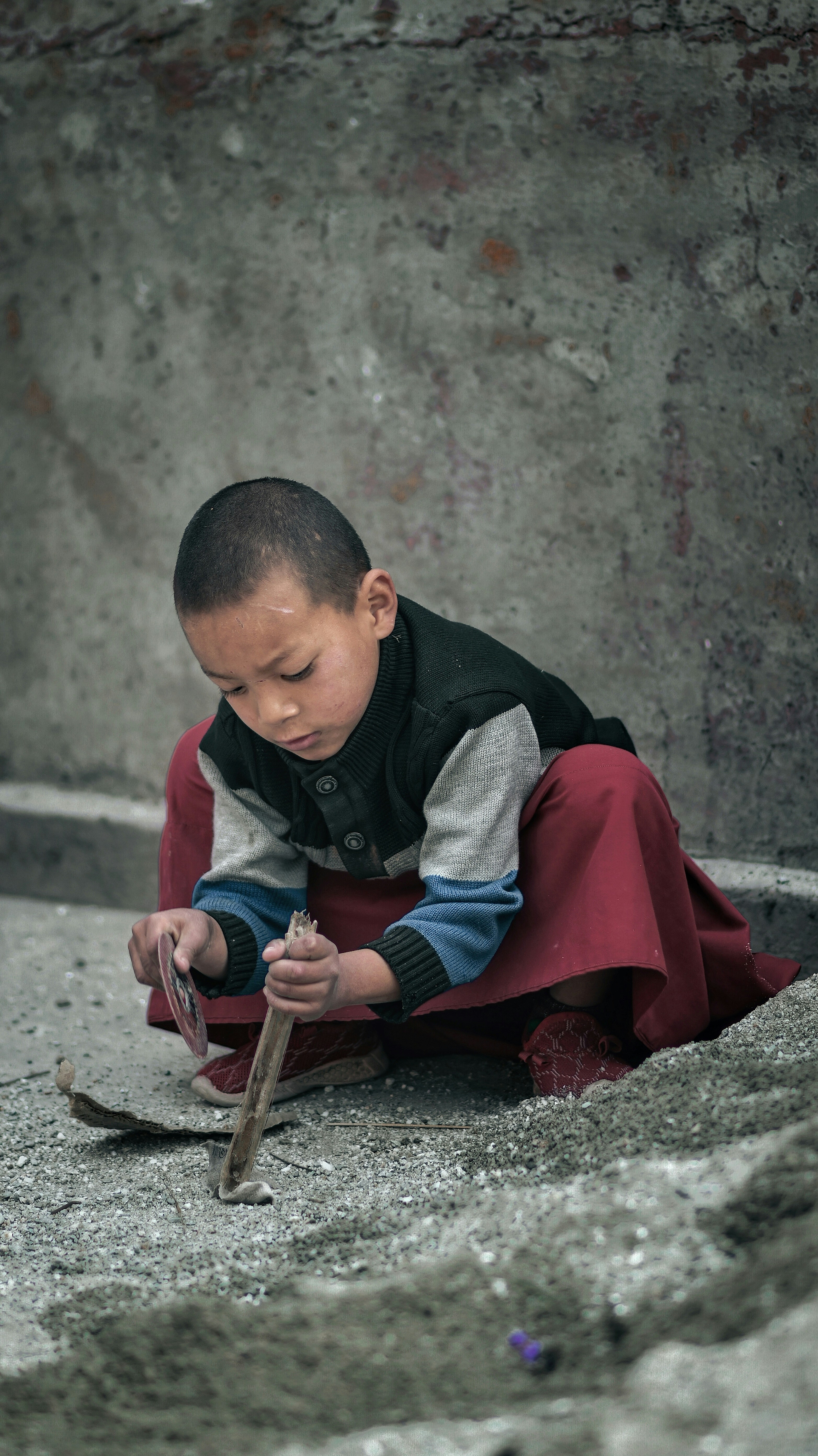 Child with Bone Fragment: Quiet Moment Amid Rubble