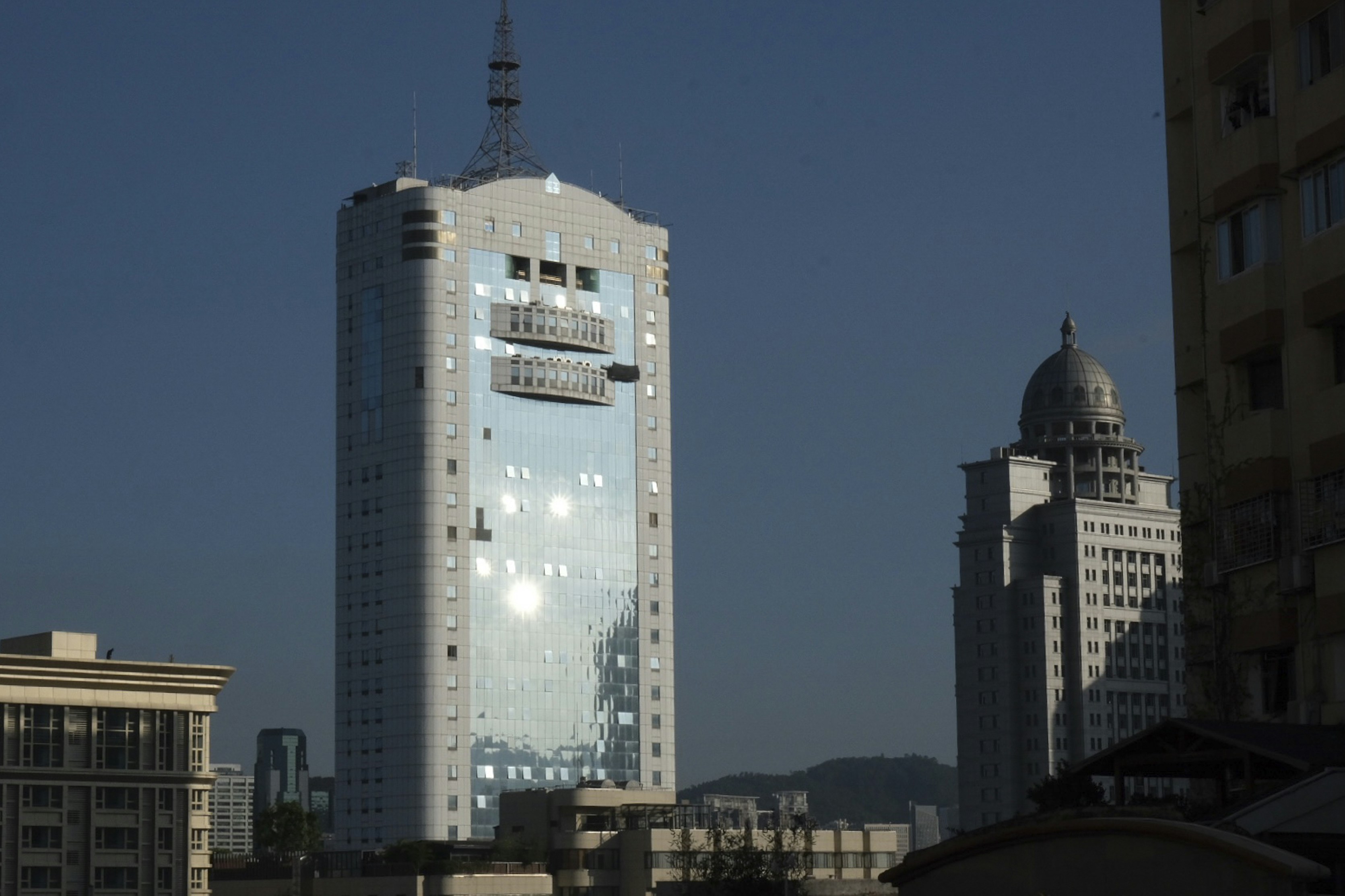 A tall building with a sky scraper in the background photo – Free City ...