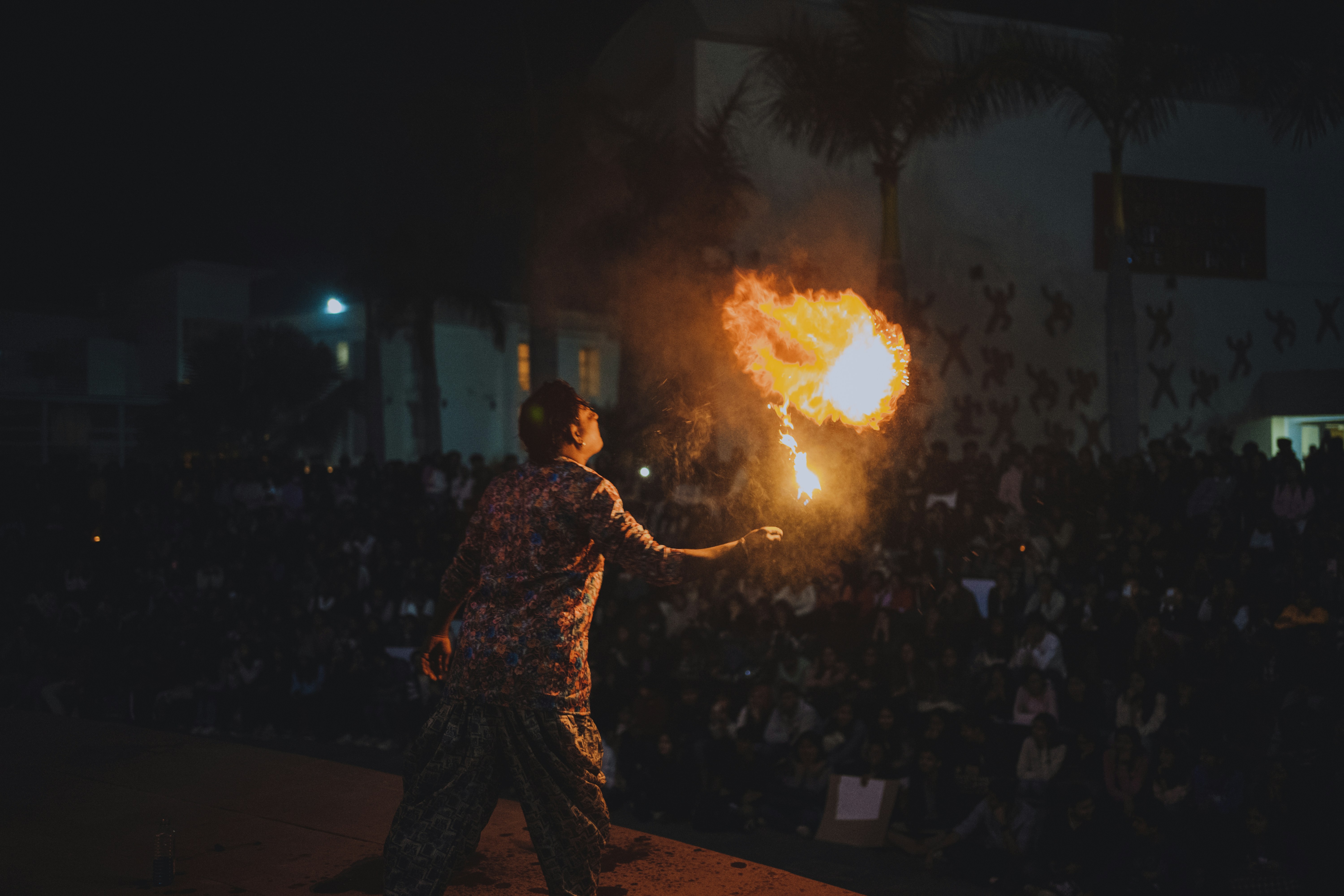 a person holding a fire ball in front of a crowd
