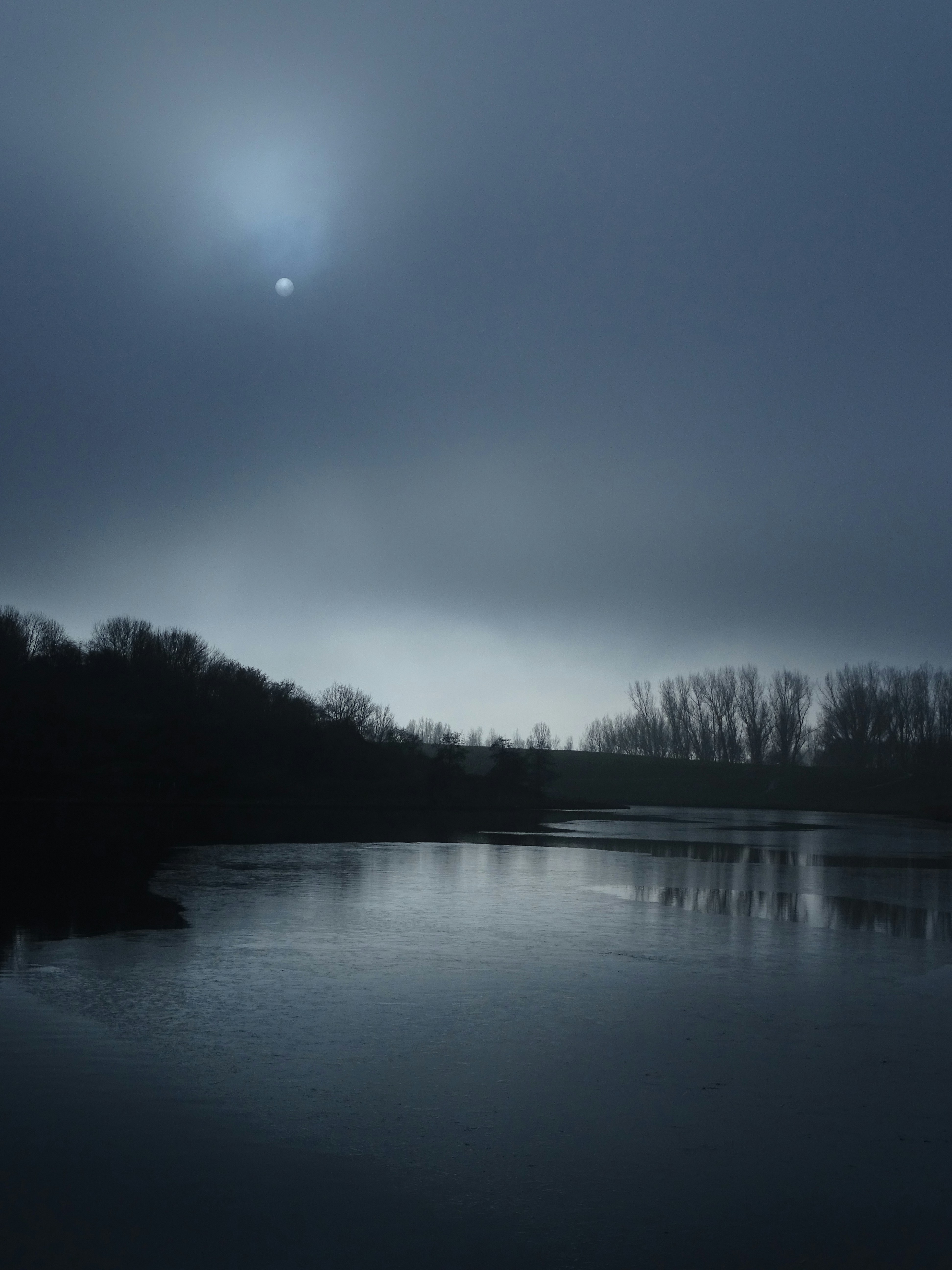 Moonlit Mist over the River: Pale Orb in a Blue-Gray Sky
