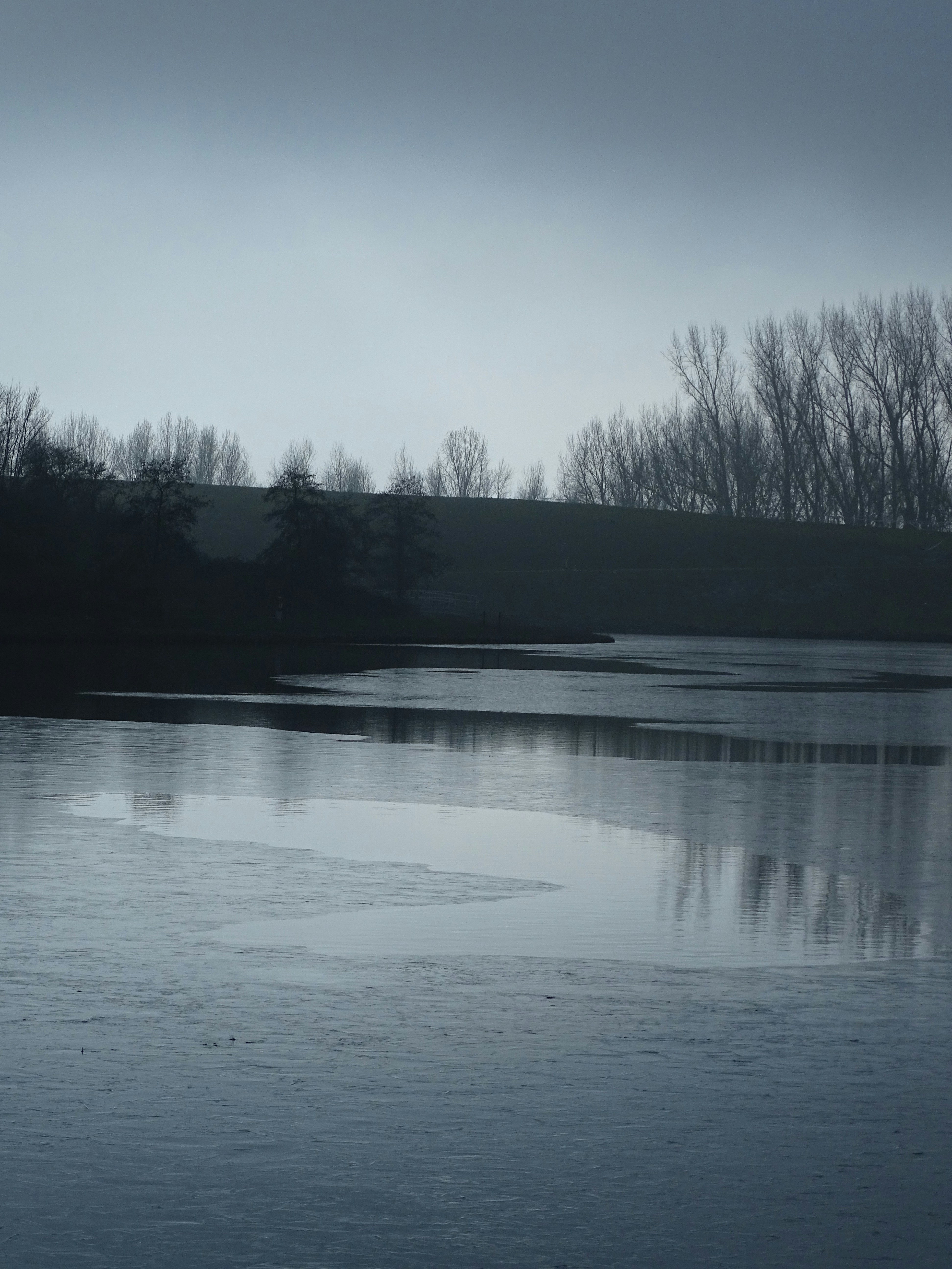 Blue Hour Silhouettes Across a Calm, Partially Frozen Lake