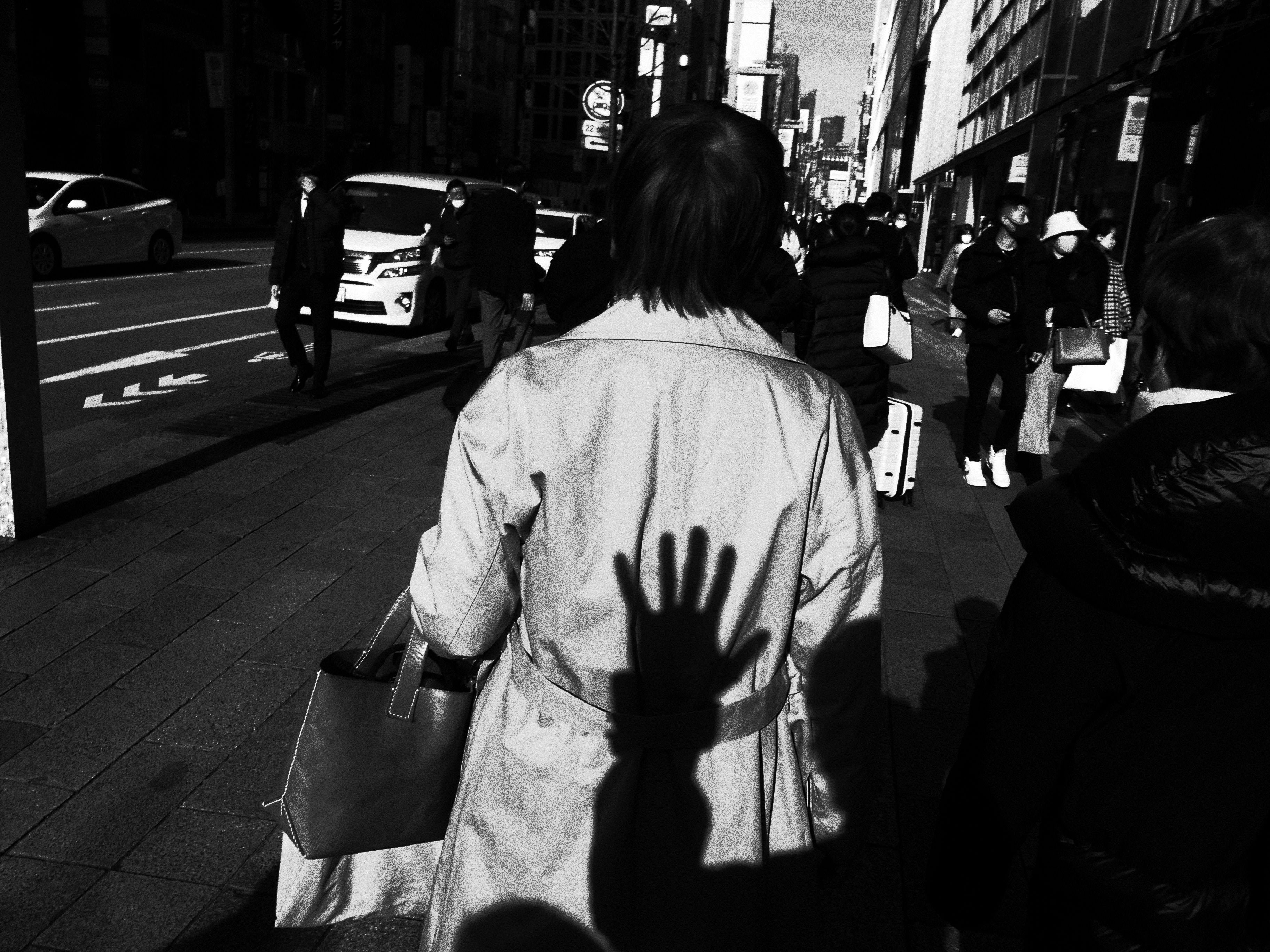 Shadow Hand Across the City: A Back-Facing Portrait in Monochrome