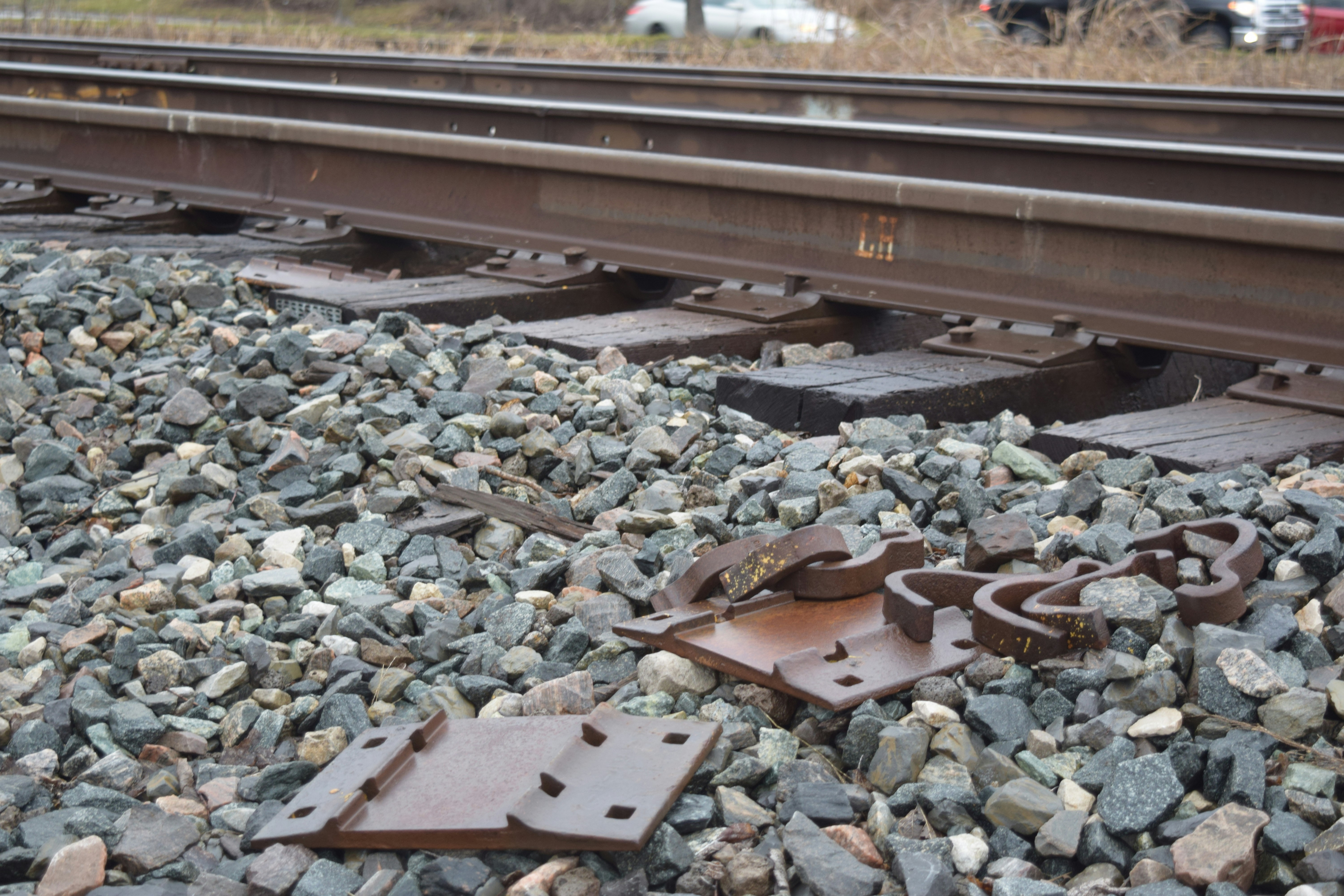 Underfoot Relics: Rusted Rail Fasteners Among Crushed Stone