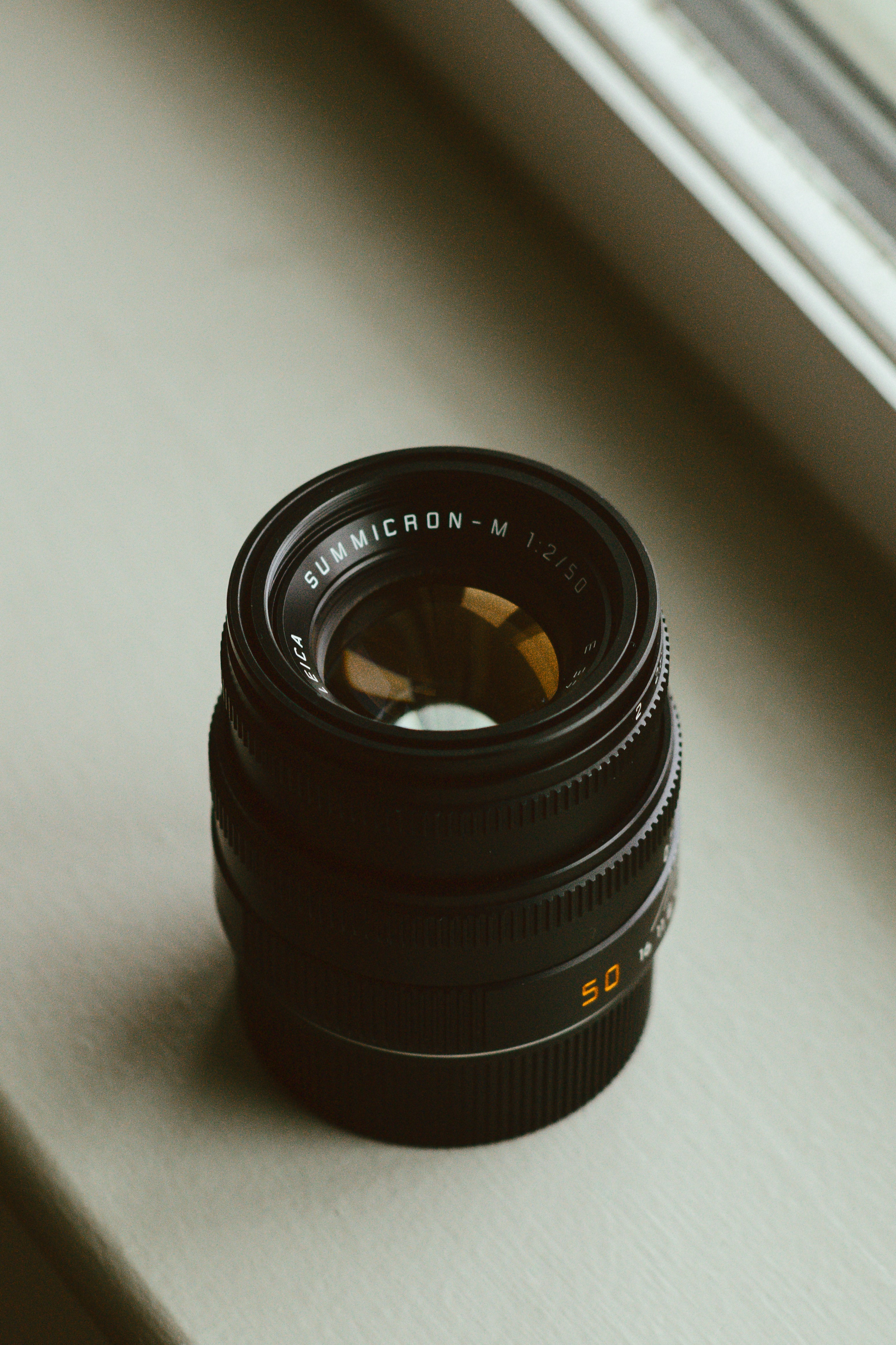A camera lens sitting on top of a window sill photo – Free Electronics ...