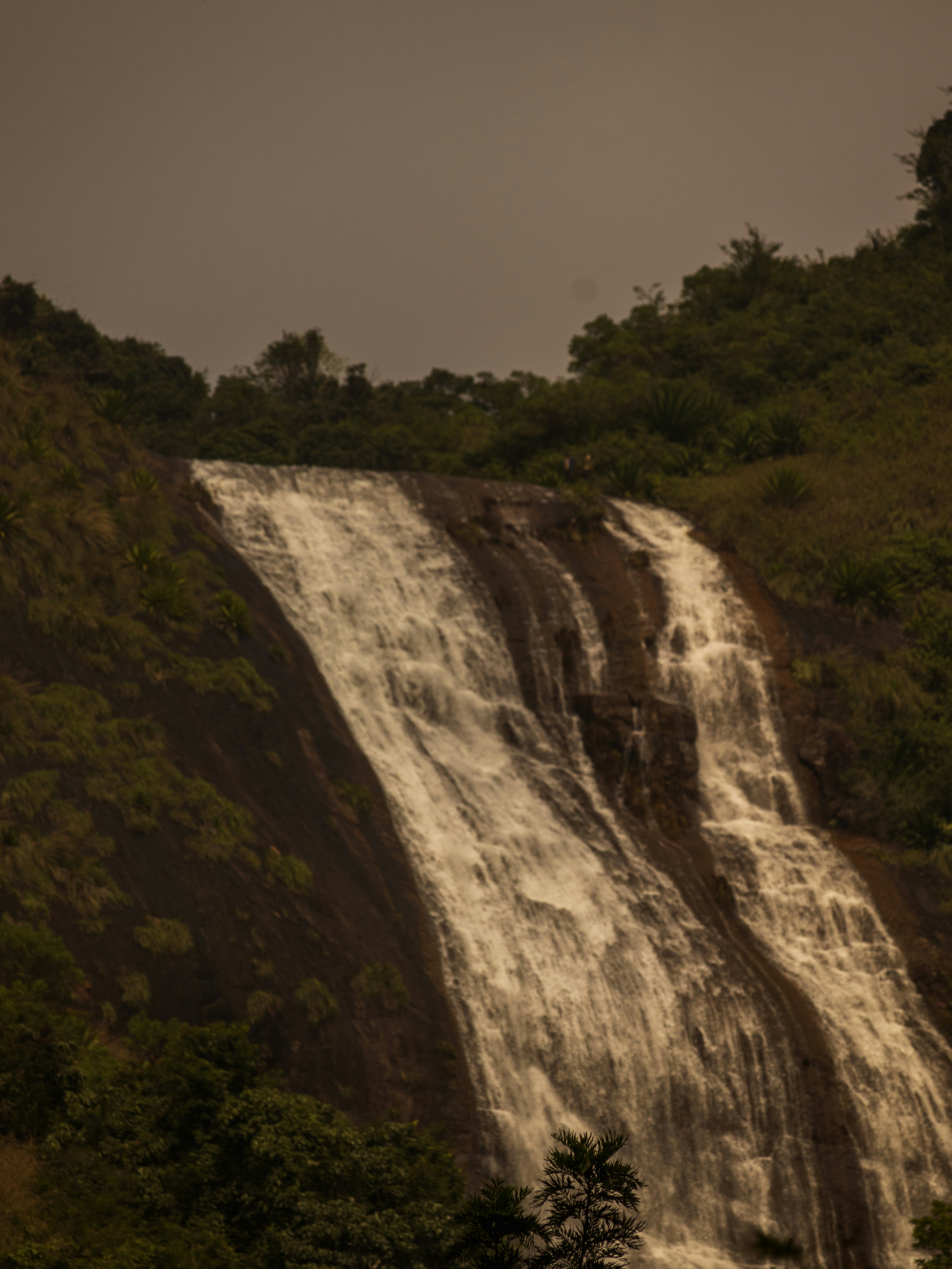 A very tall waterfall in the middle of a forest photo – Free Water ...