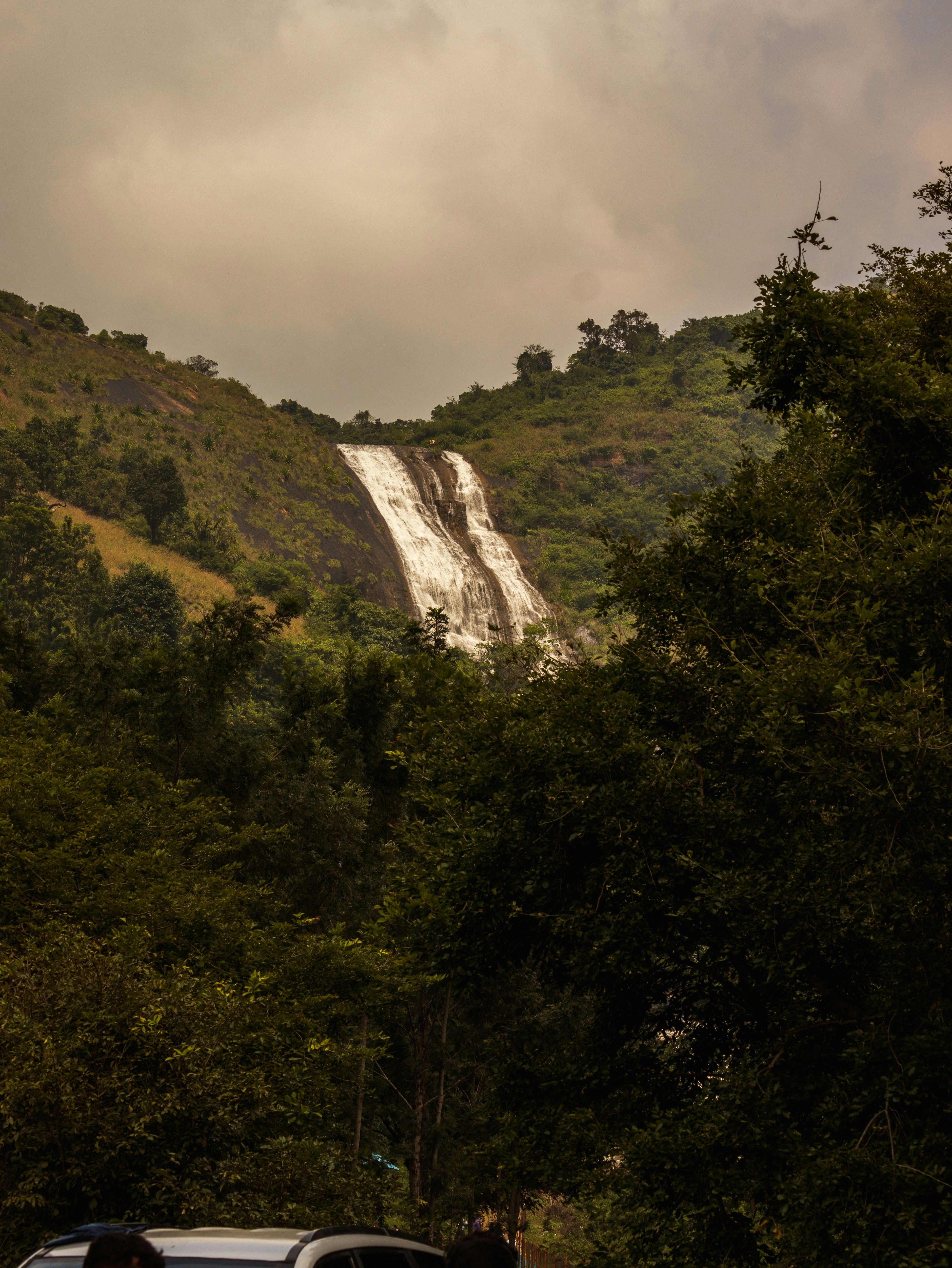 A car driving down a road next to a waterfall photo – Free Tamil nadu ...