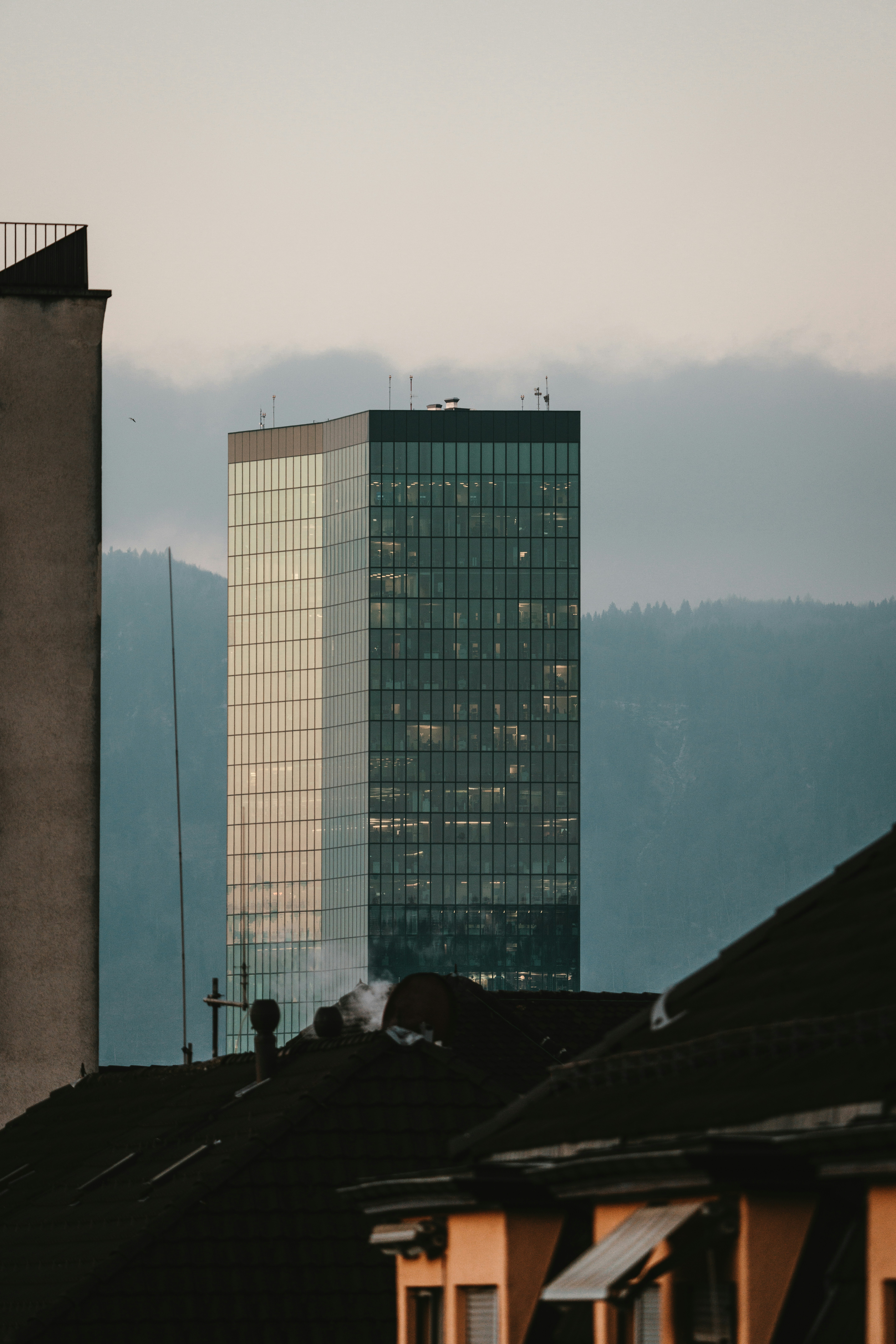 Foto Un edificio alto con un rascacielos en el fondo – Imagen Zúrich gratis en Unsplash
