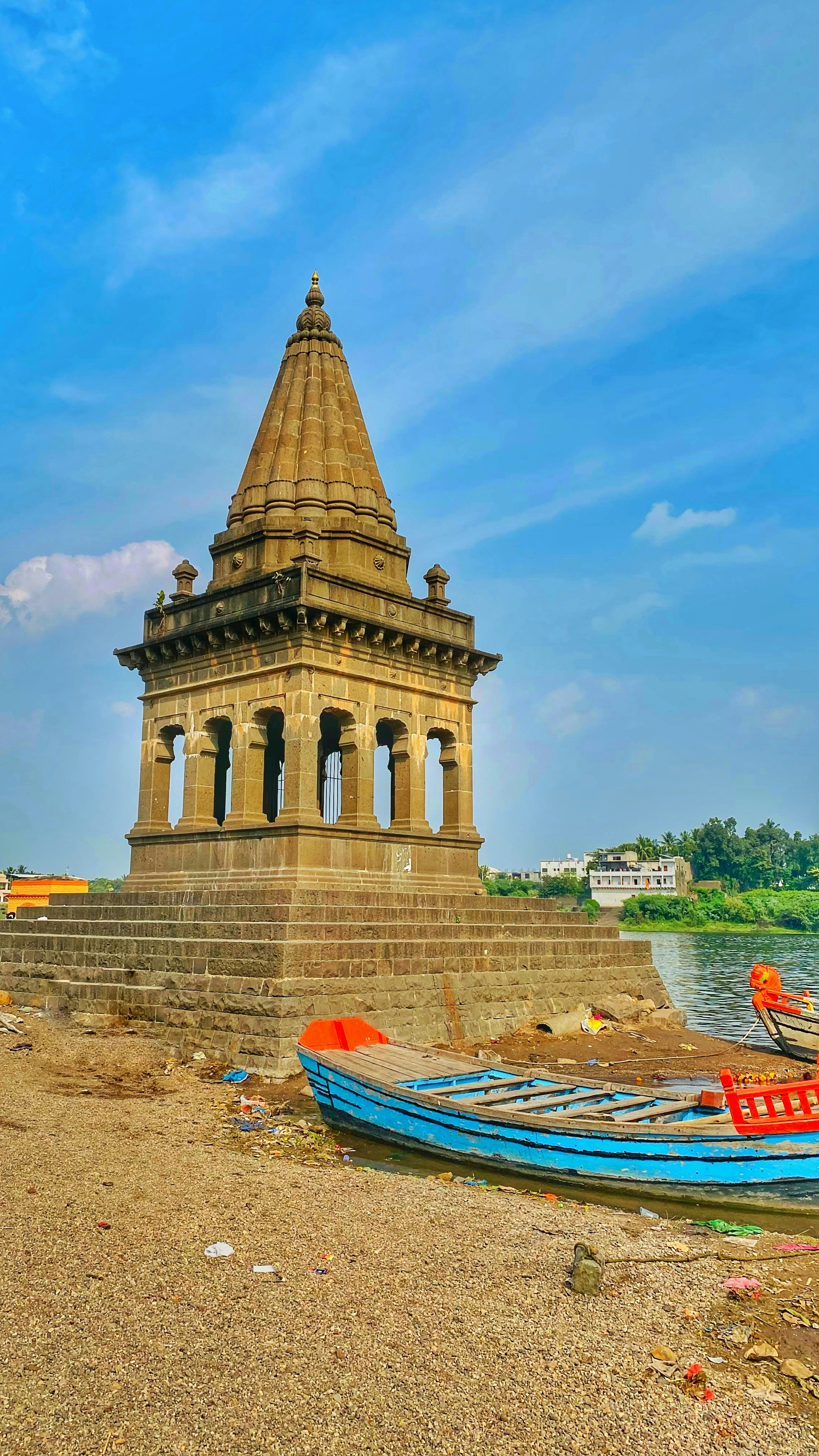 Riverside Stone Tower: A Sunlit Monument Framing Boats and Sky