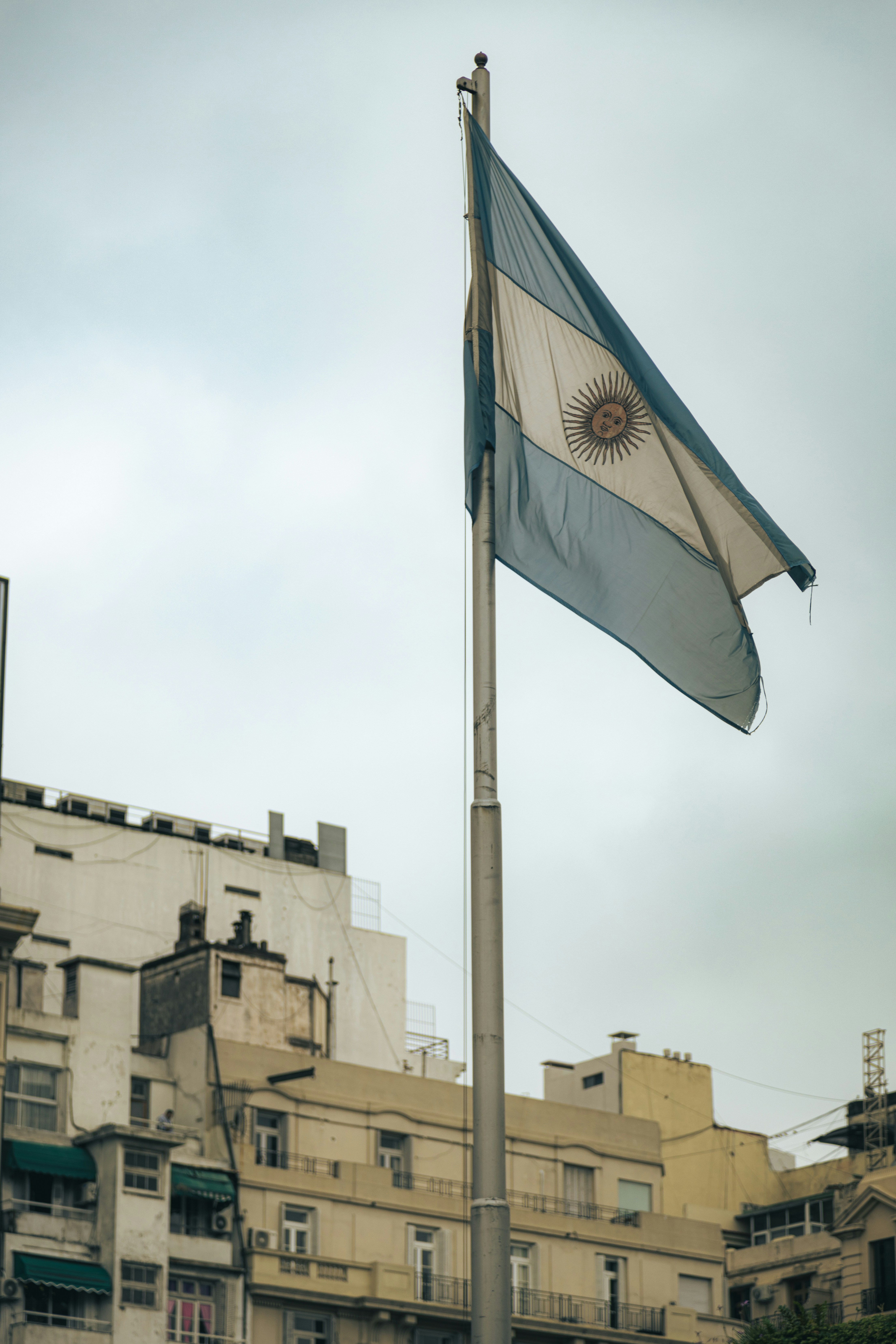 a flag flying in the wind in front of a building