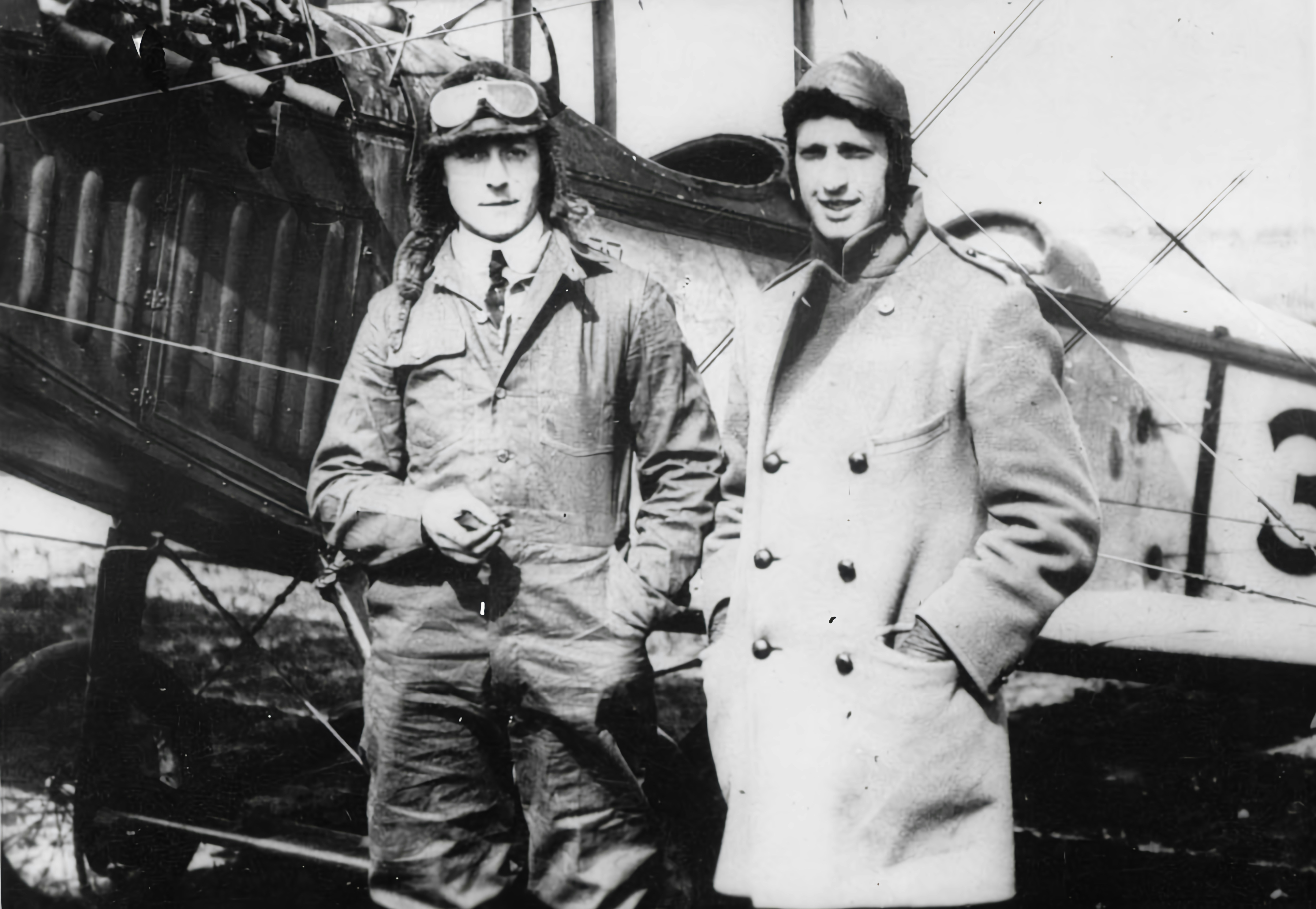 A couple of men standing next to each other in front of a plane photo ...