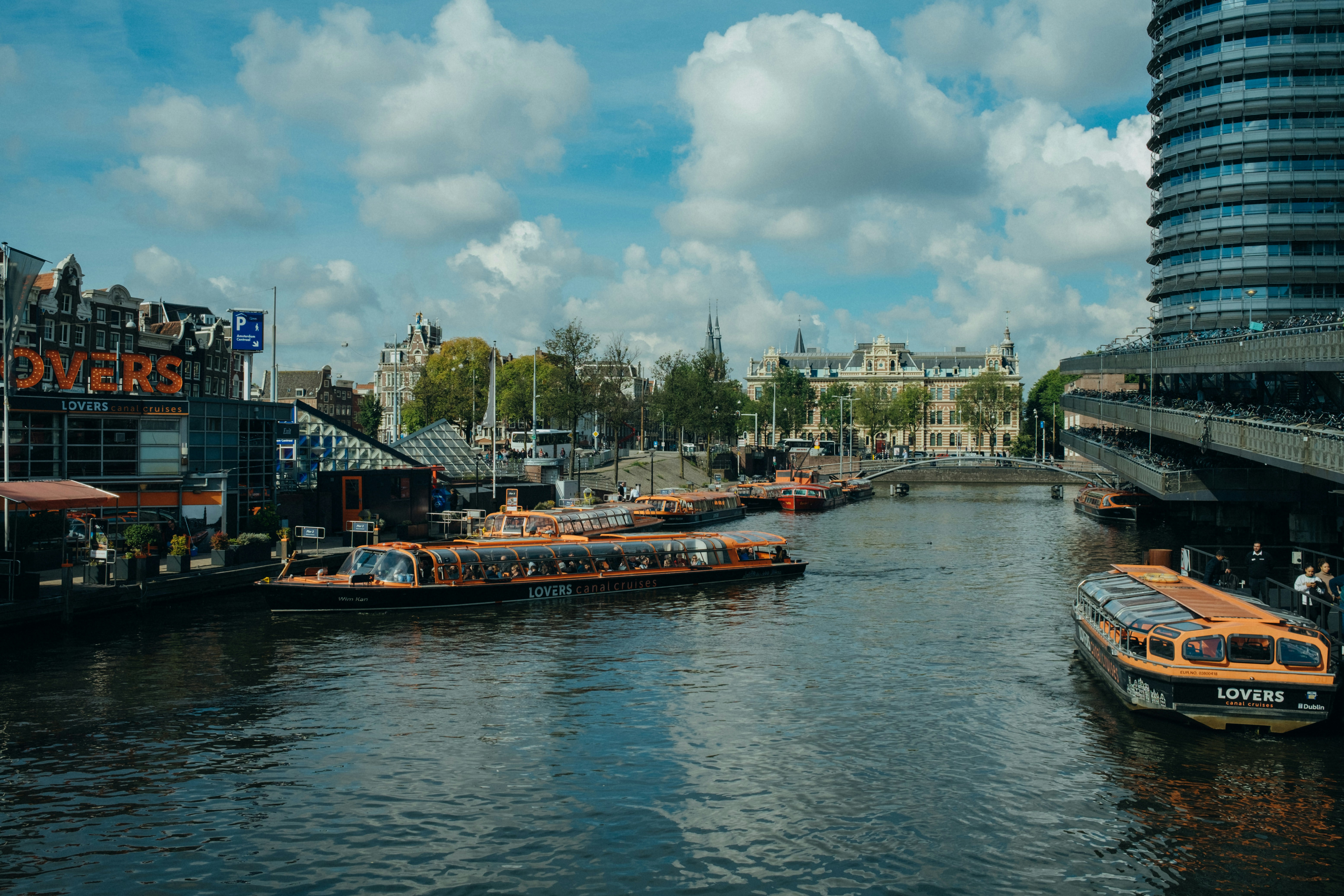 Riverfront Confluence: Orange Boats and Glass-Walled Tower on the Thames