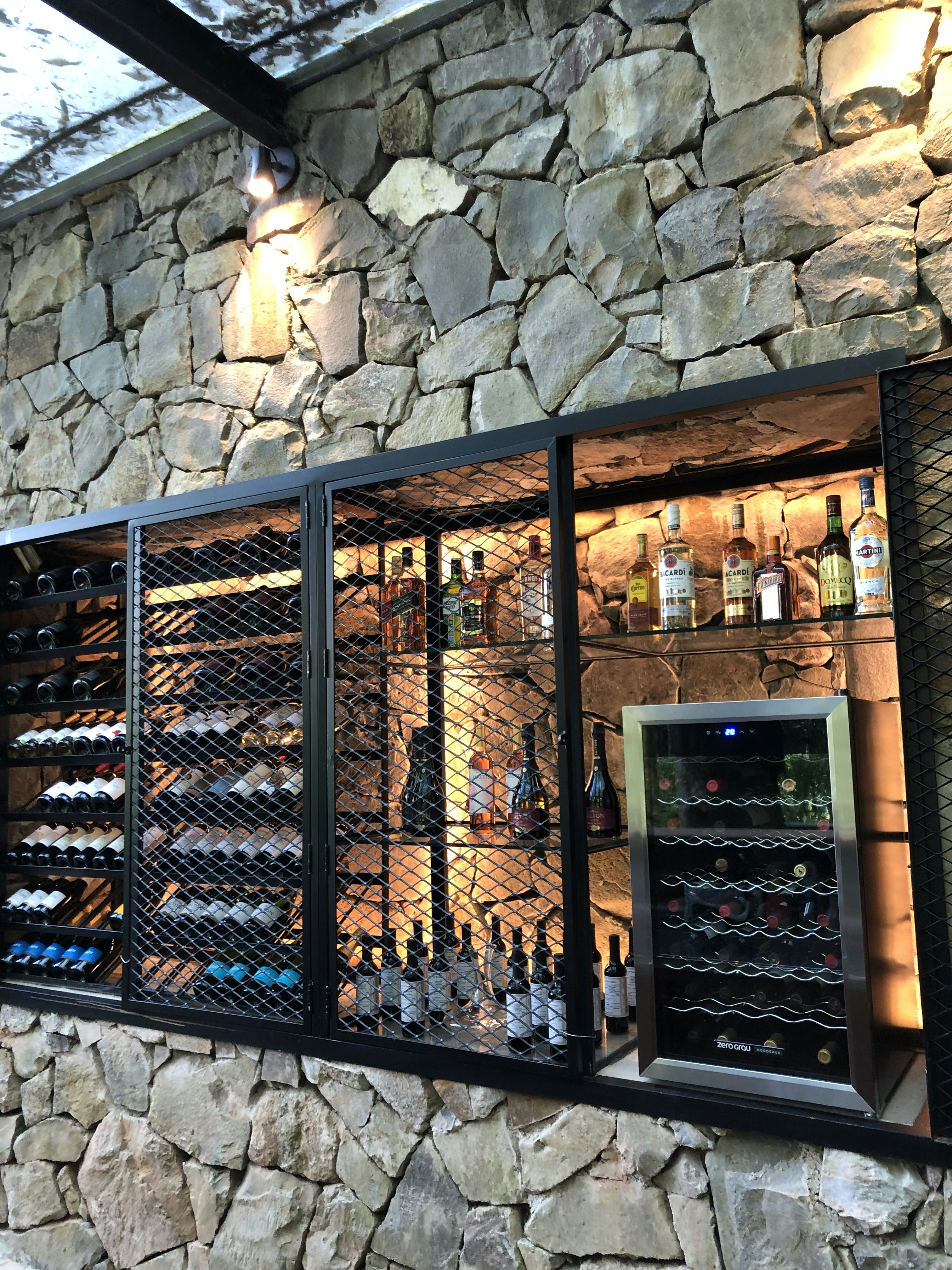 Wine Vault at Dusk: Bottles Shelved Behind a Glassed Cellar