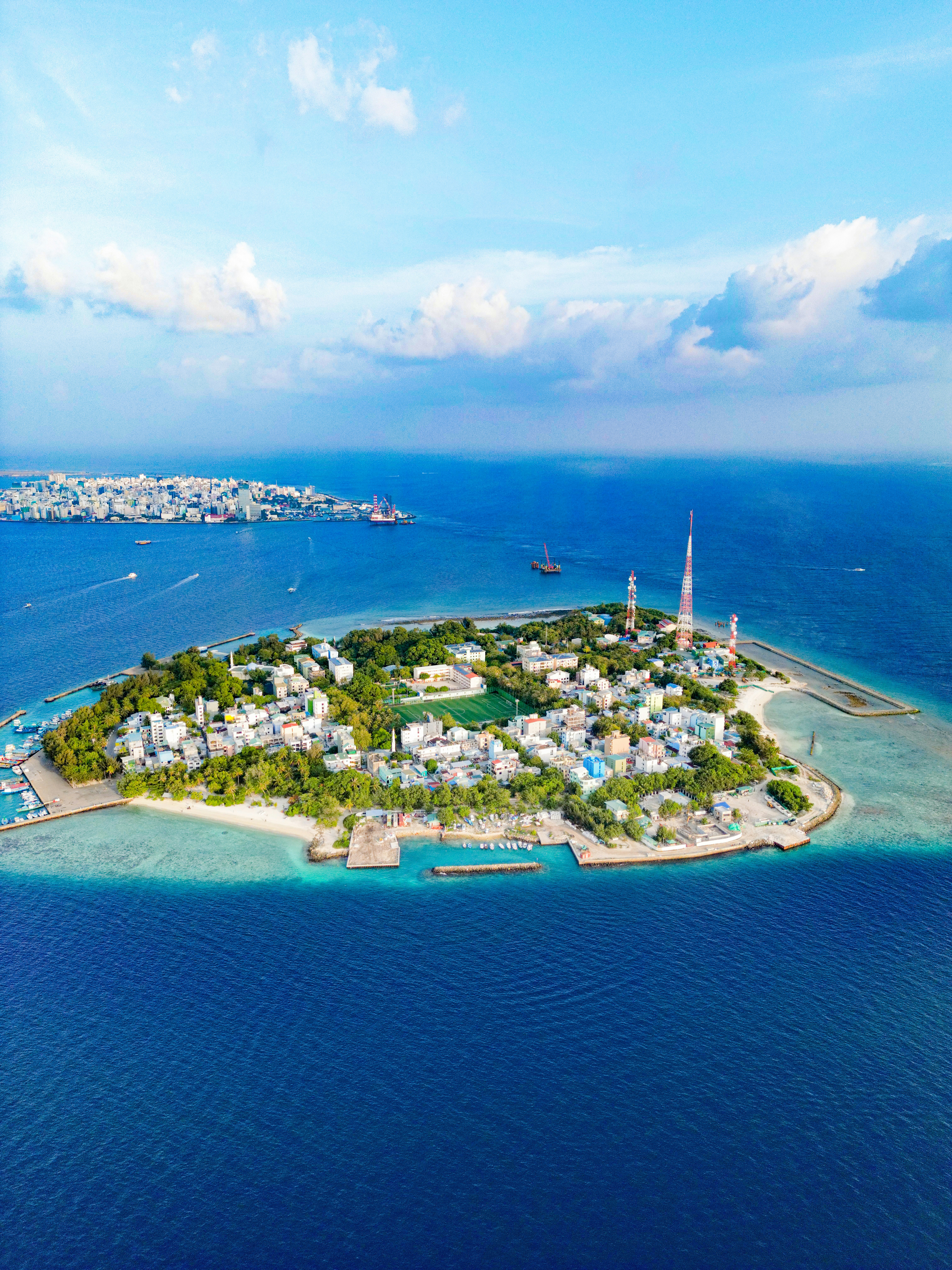 Isolated Island Parade: Aerial View of a Coastal Enclave with Tower and Boats