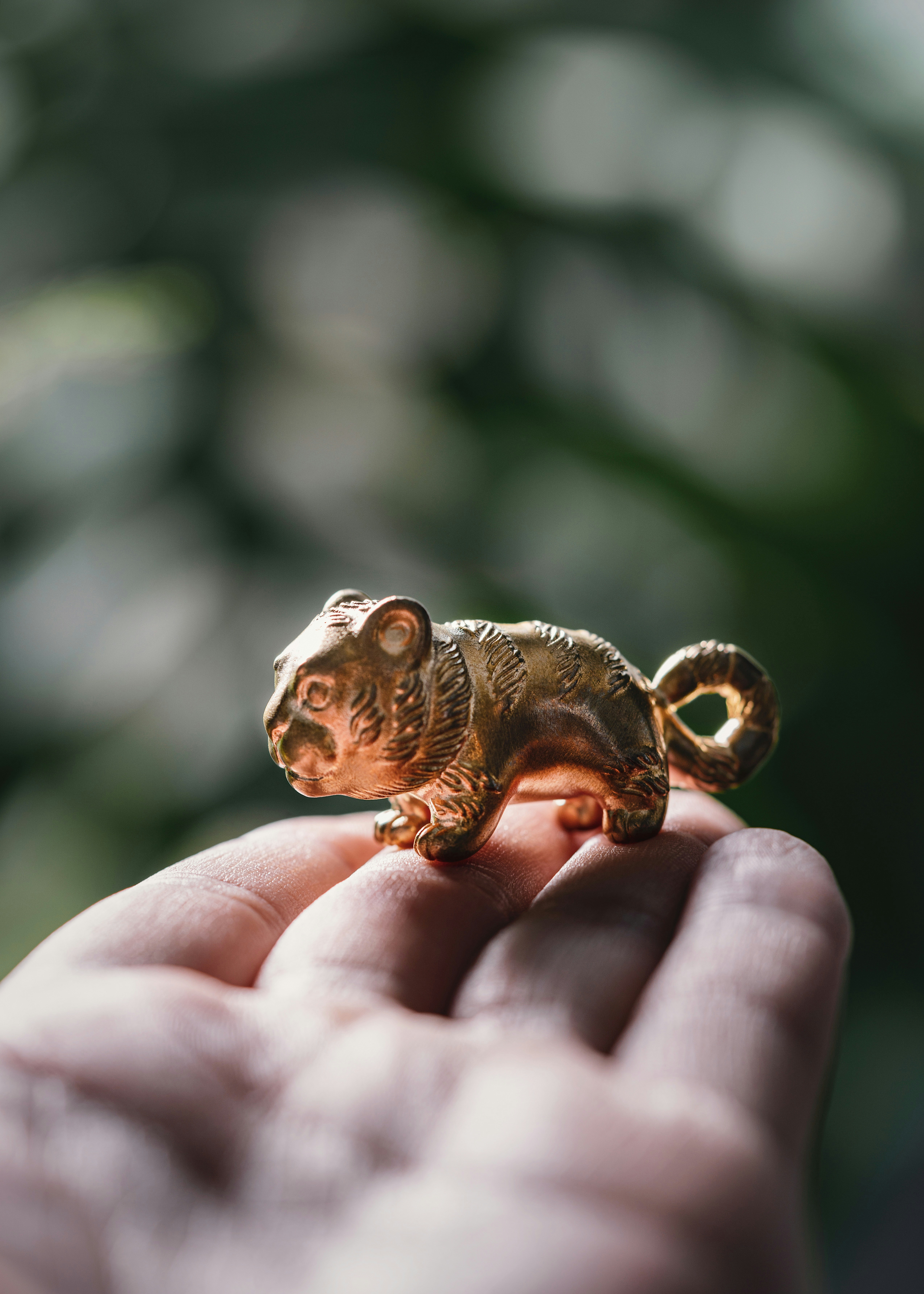 Tiny Golden Tiger in Hand: A Delicate Moment of Craft and Light