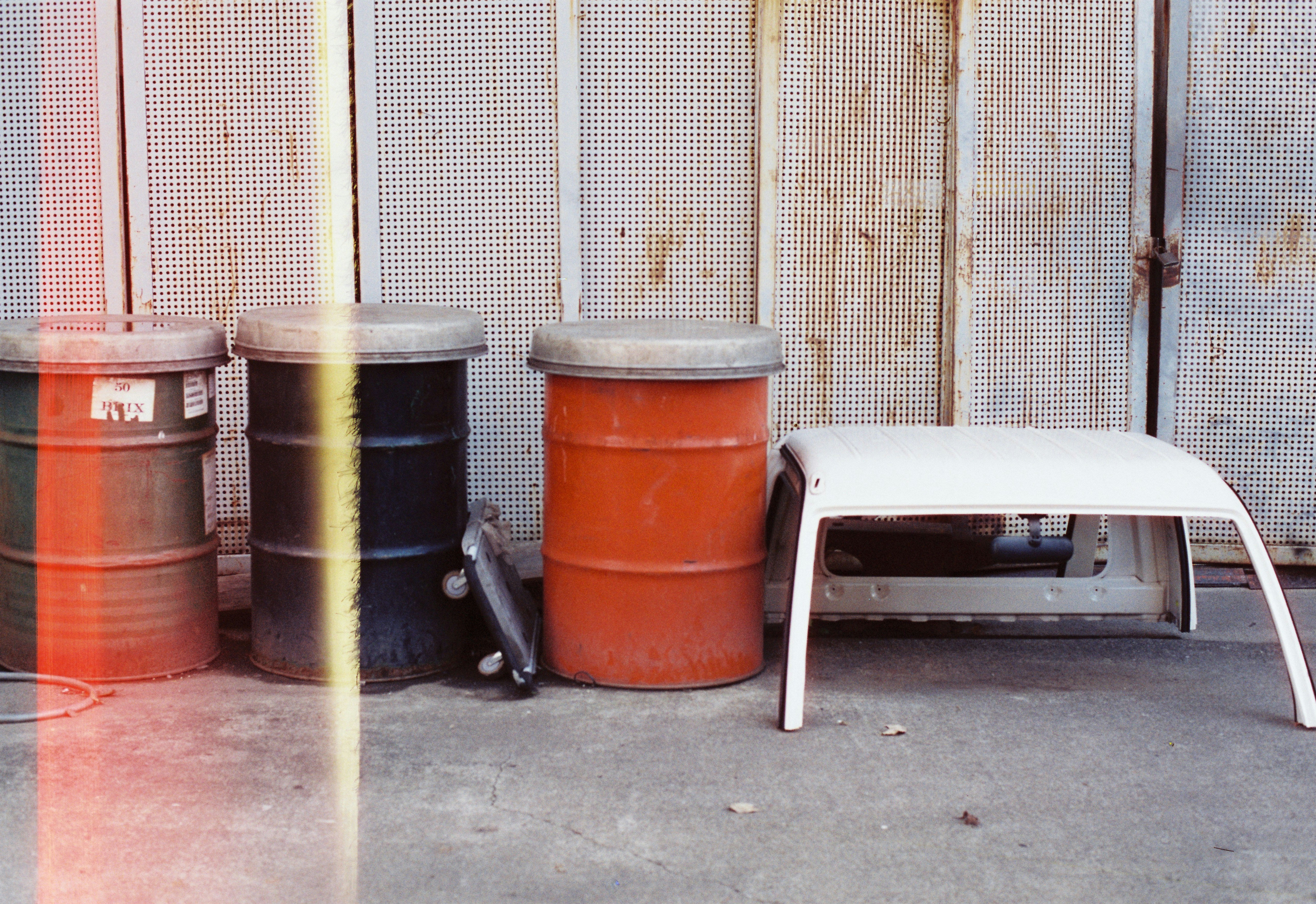 Industrial Palette: Red Canisters and a White Frame against a Worn Wall