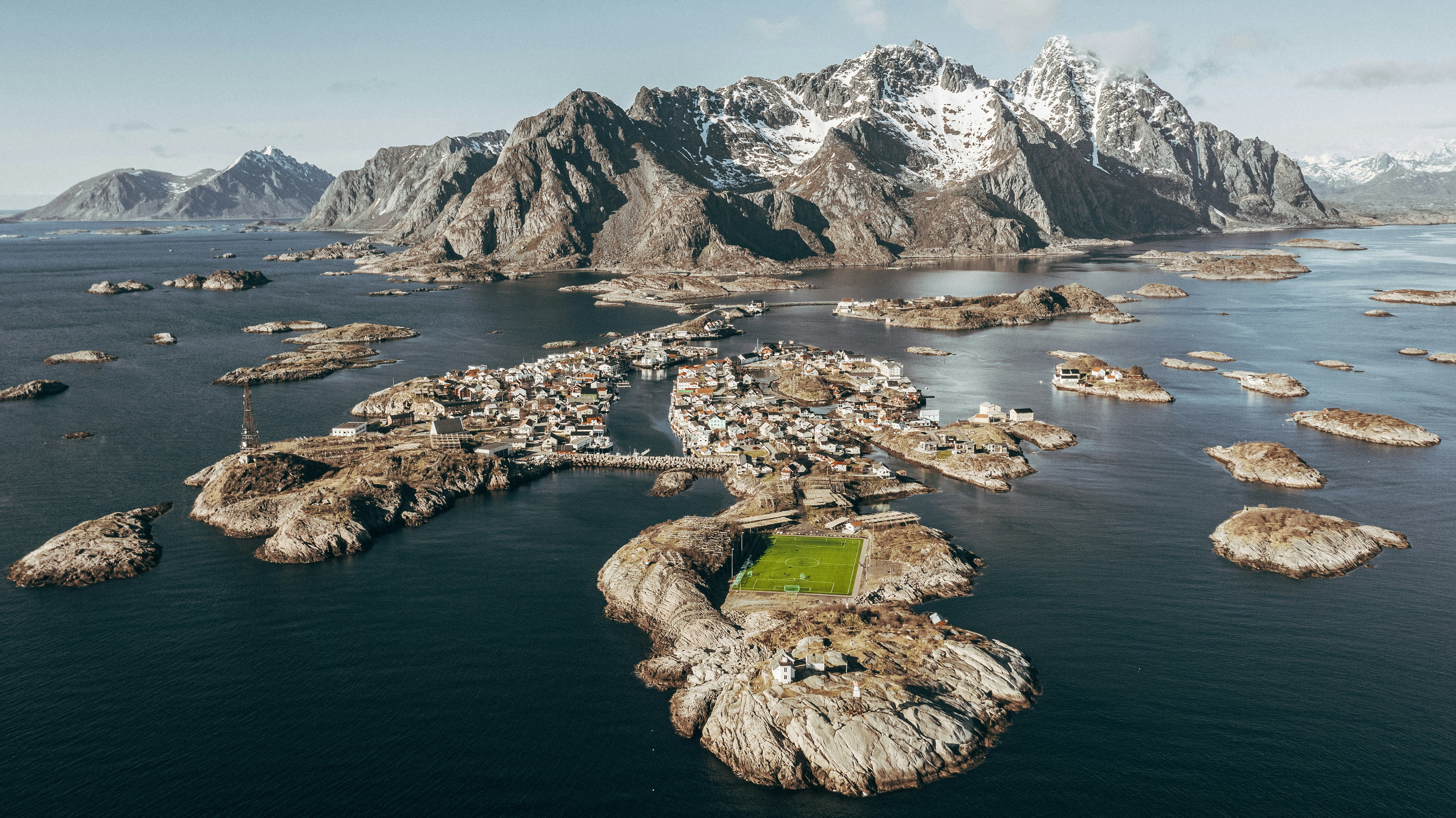 Green Patch Among Granite Islands Under Snow-Capped Peaks