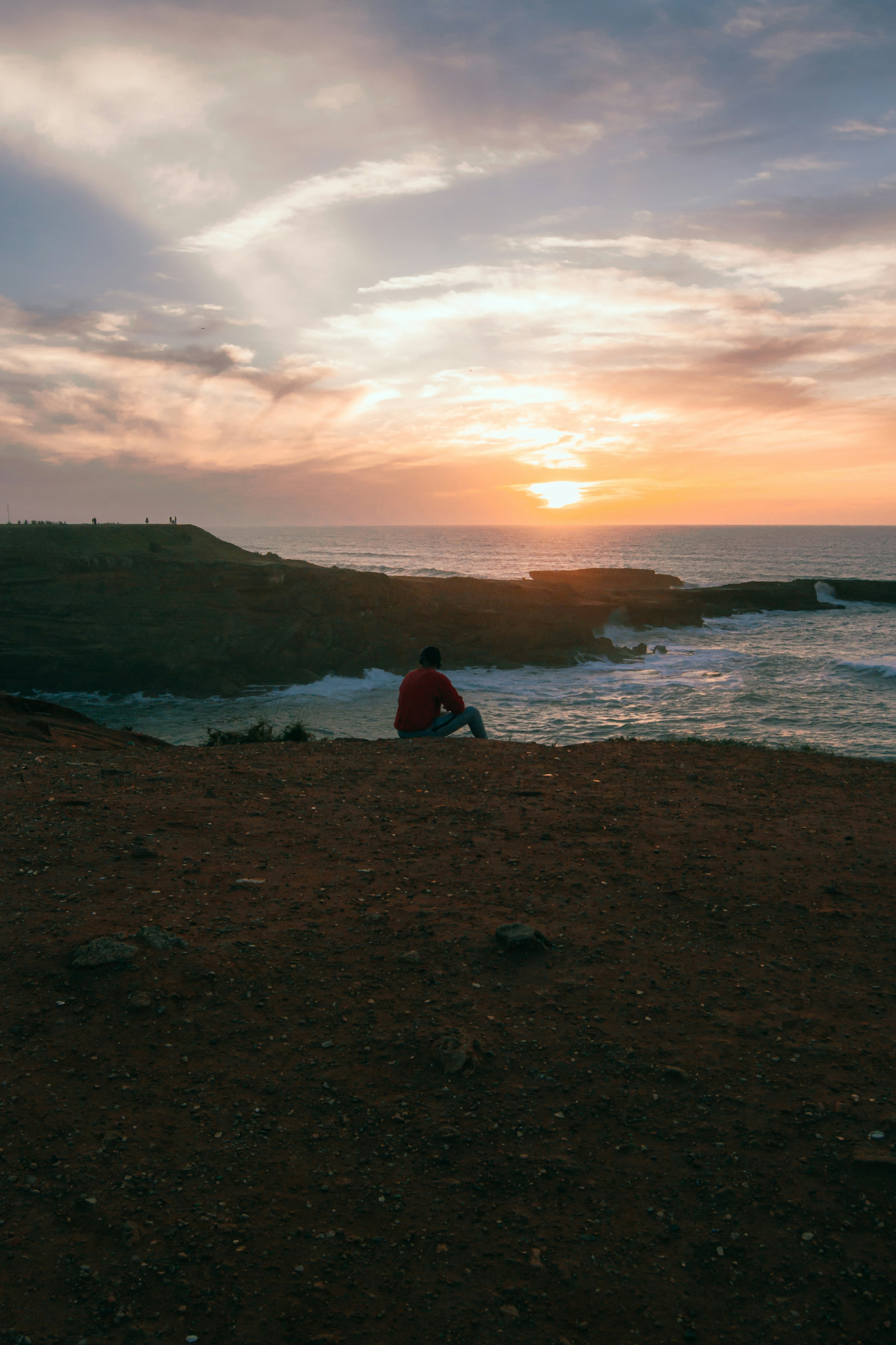 A person sitting on the beach watching the sunset photo – Free Outdoors ...
