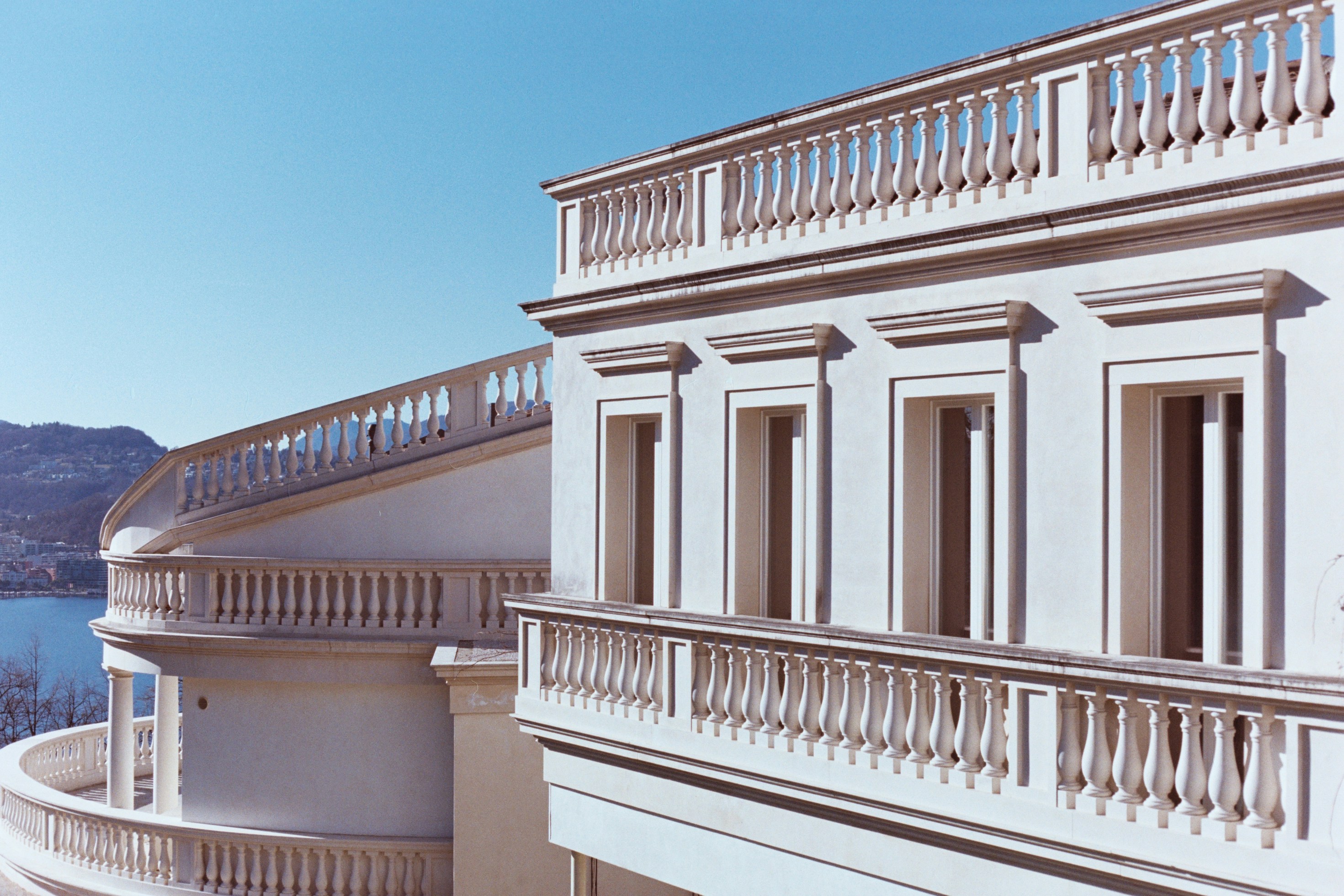 A white building with balconies overlooking a body of water photo ...